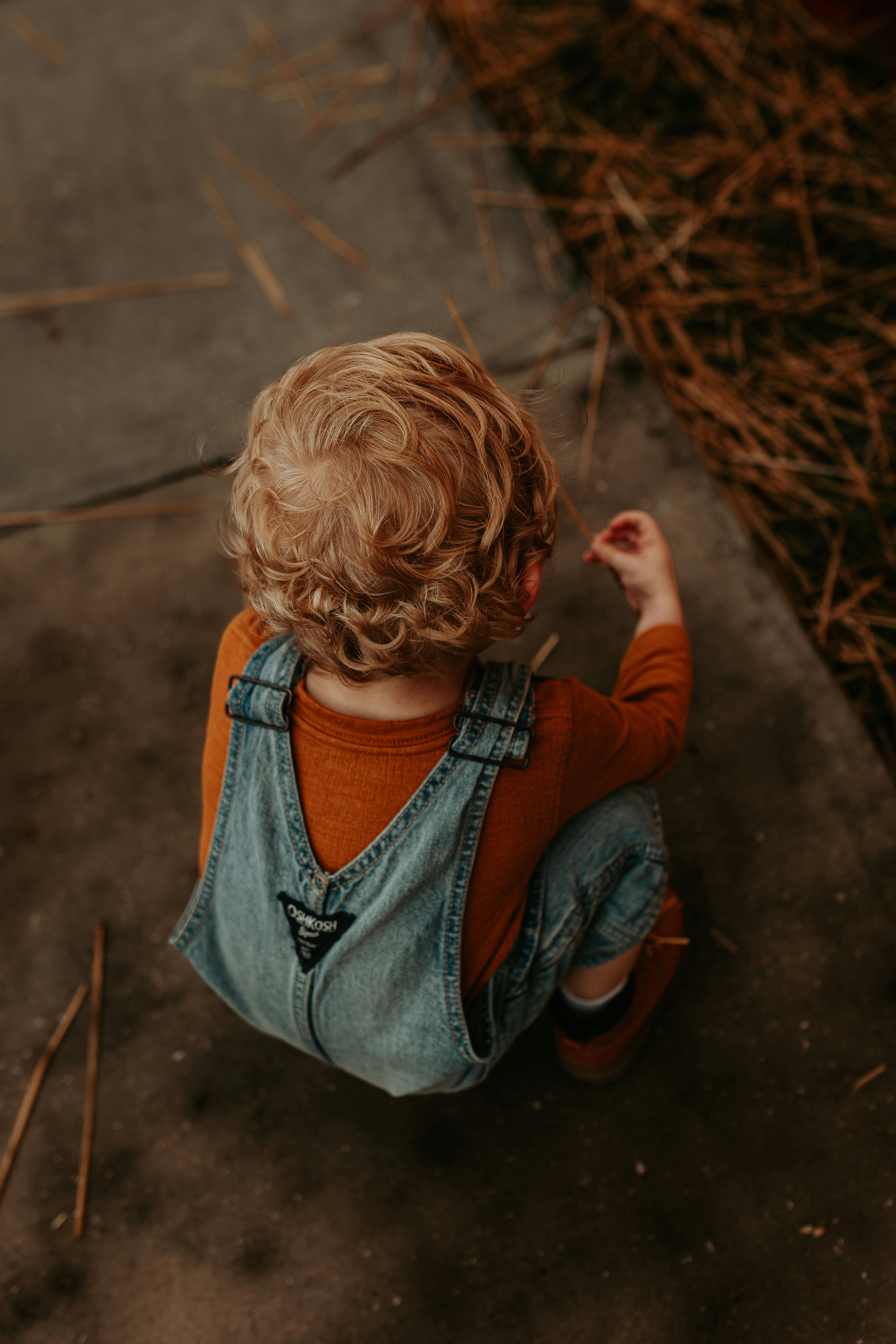 Back of a Toddler Wearing Suspenders Playing Outdoors · Free Stock Photo