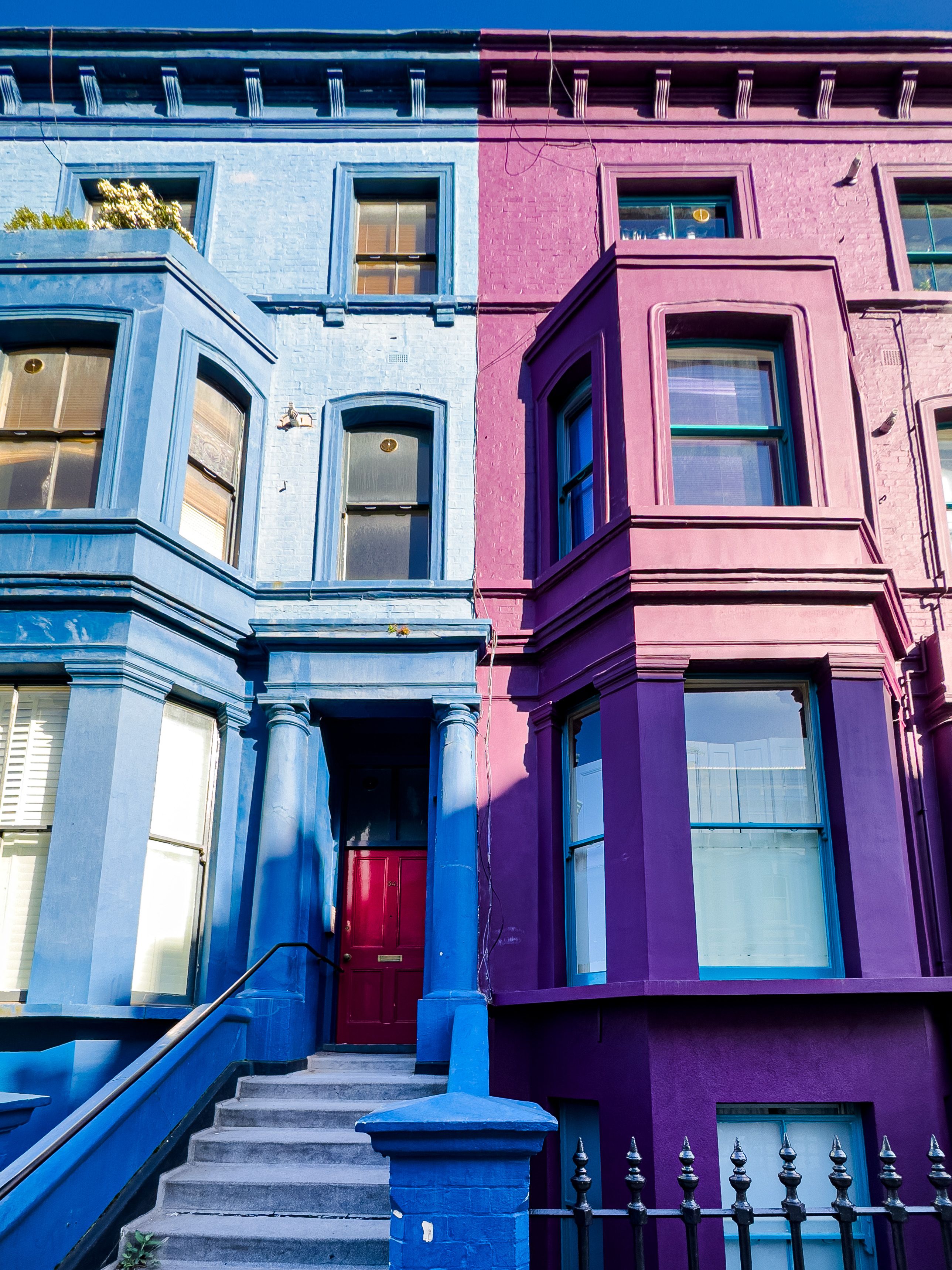 A row of colorful houses with stairs and a blue door · Free Stock Photo