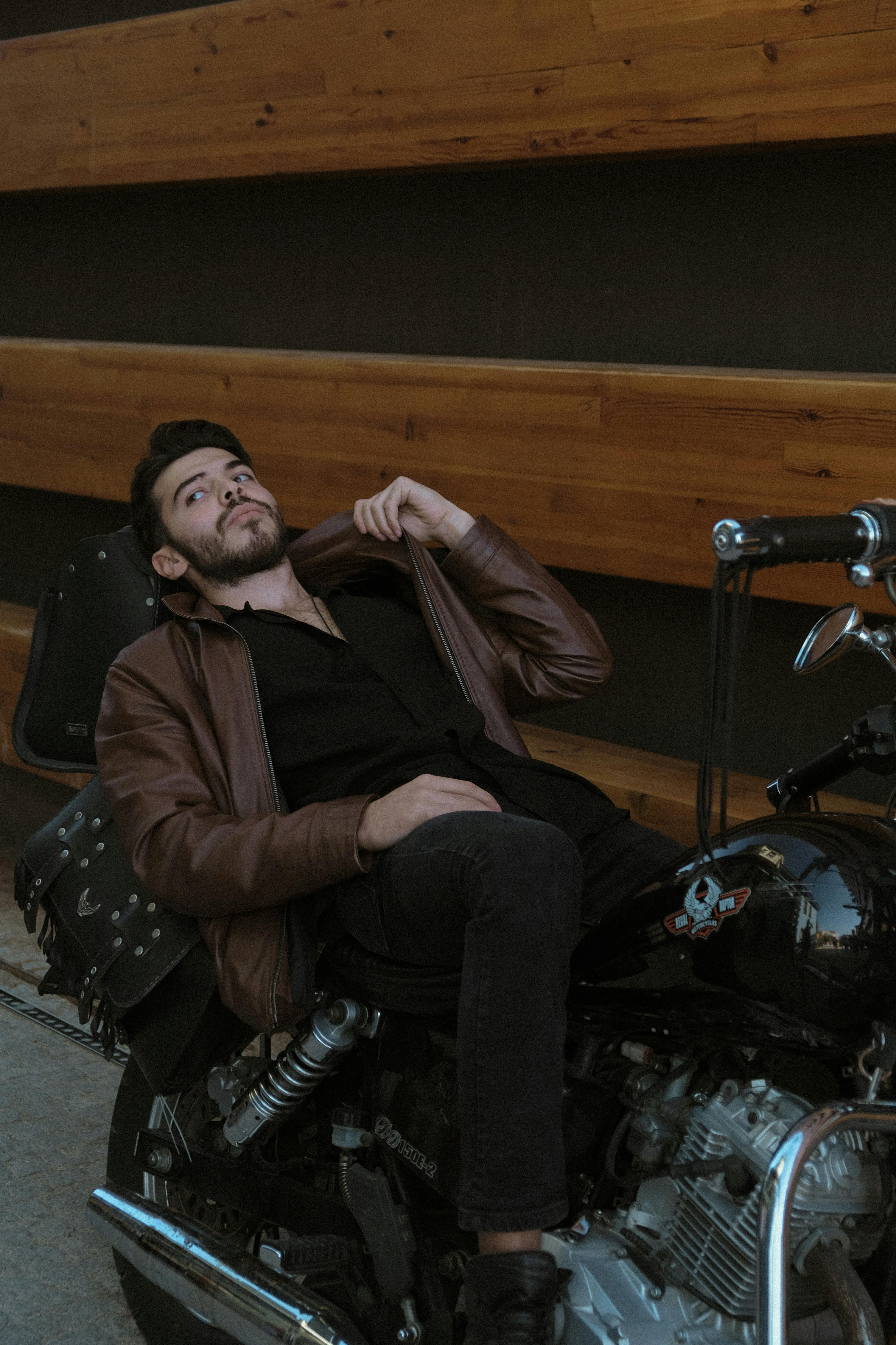 Man in Jacket Lying Down on Motorcycle · Free Stock Photo