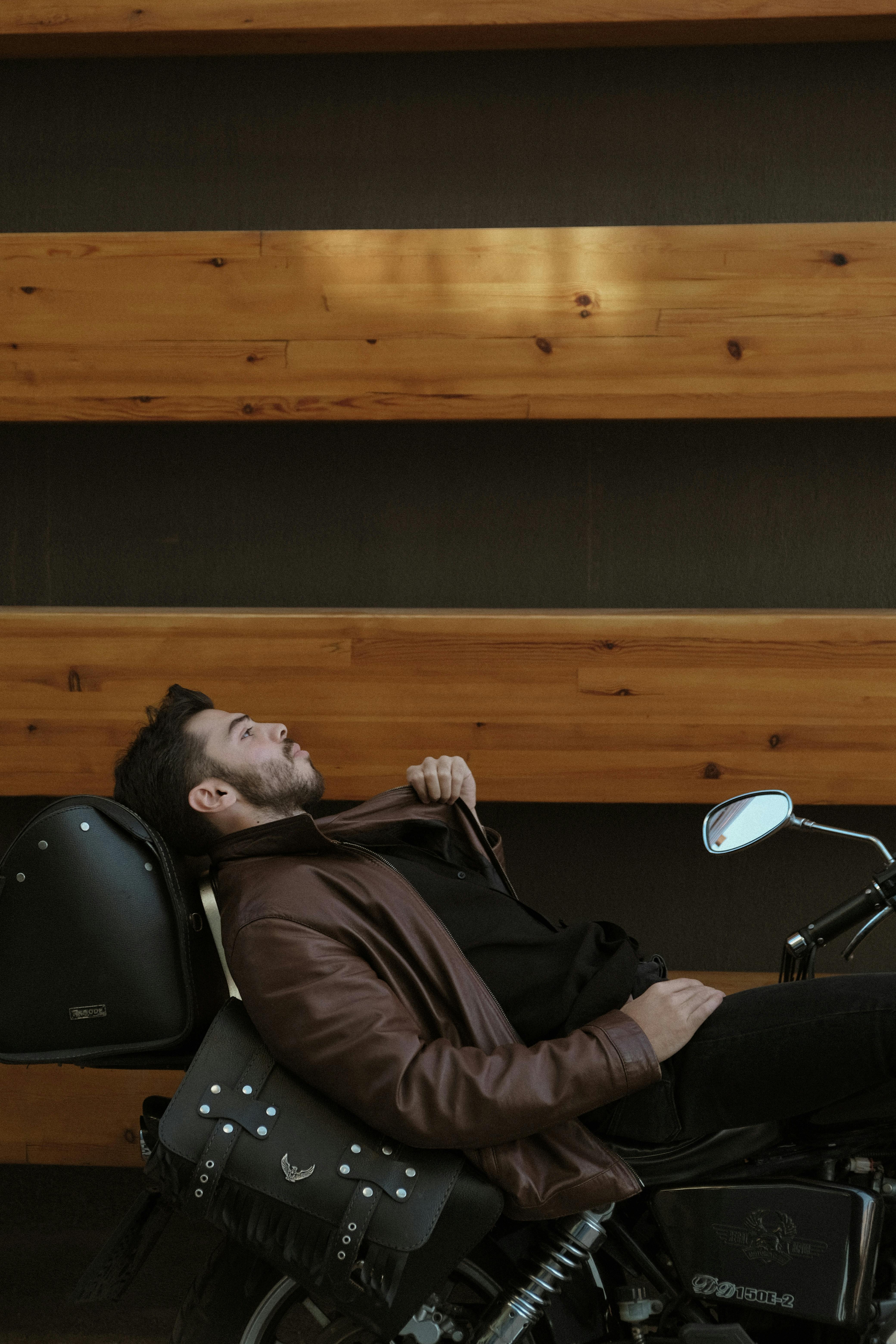 Man in Black Jacket Lying Down on Motorbike · Free Stock Photo
