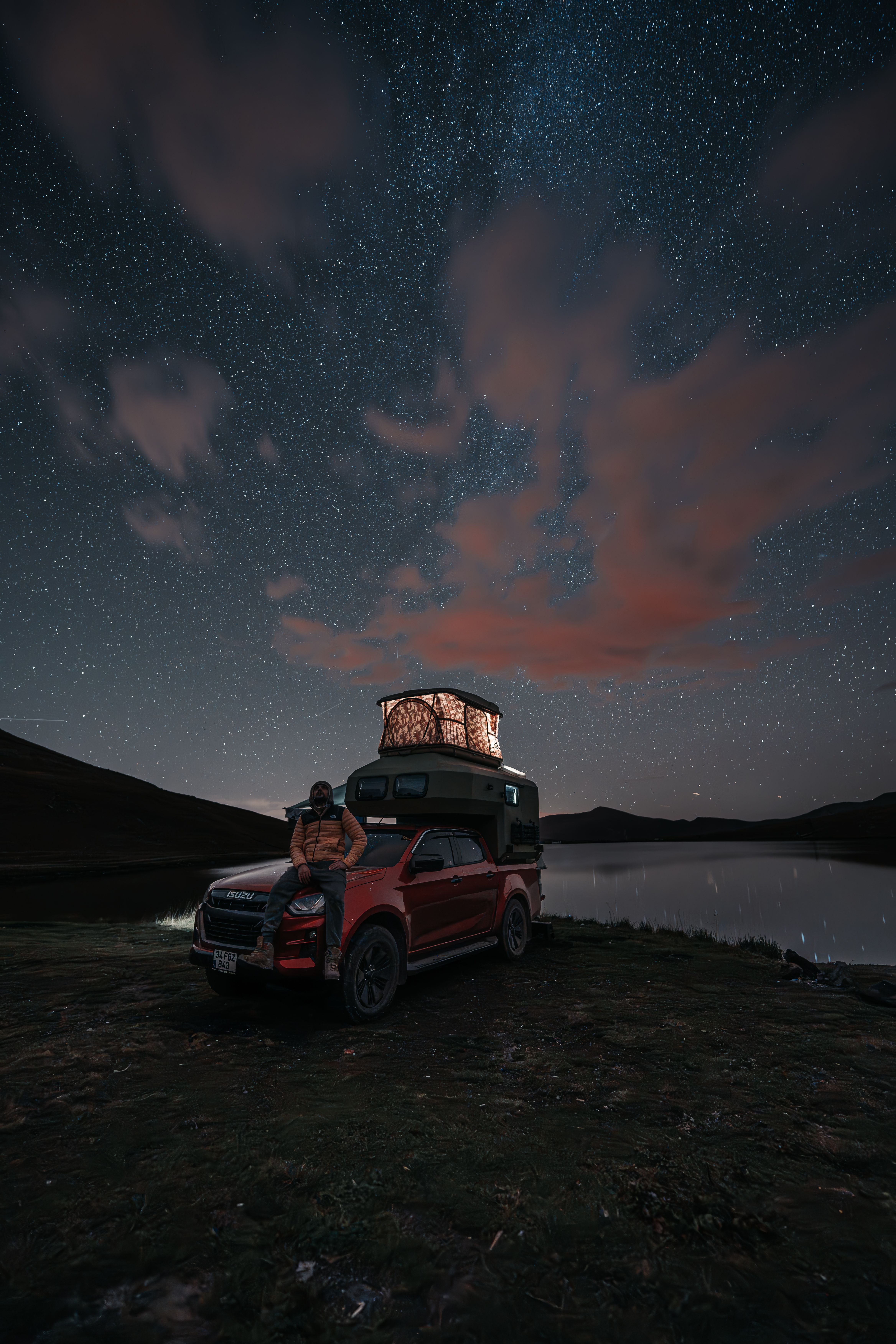 Man Sitting on Car with Tent by Lake at Night · Free Stock Photo