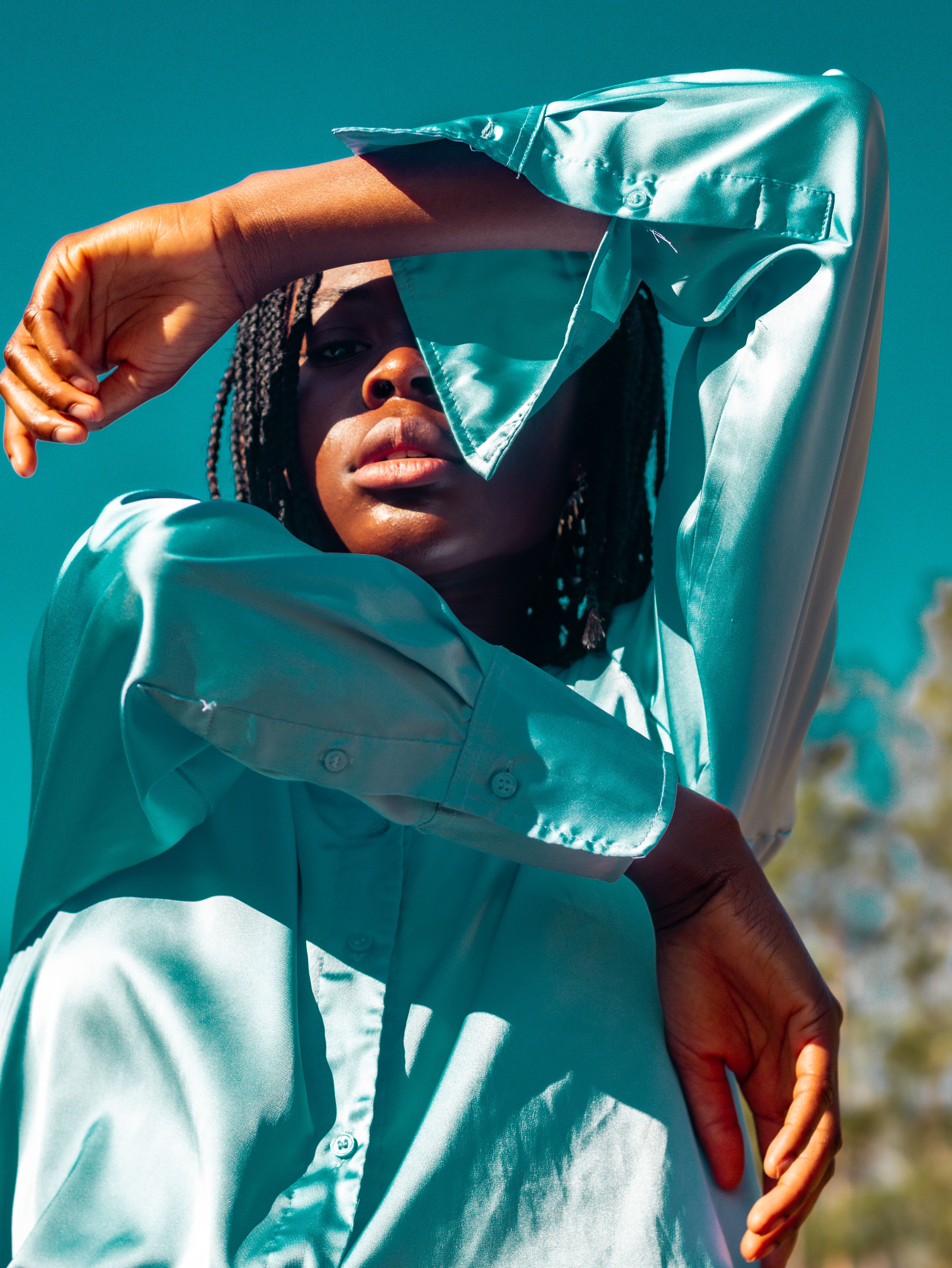 Beautiful Woman in Shiny Blue Shirt Posing in Sunlight · Free Stock Photo