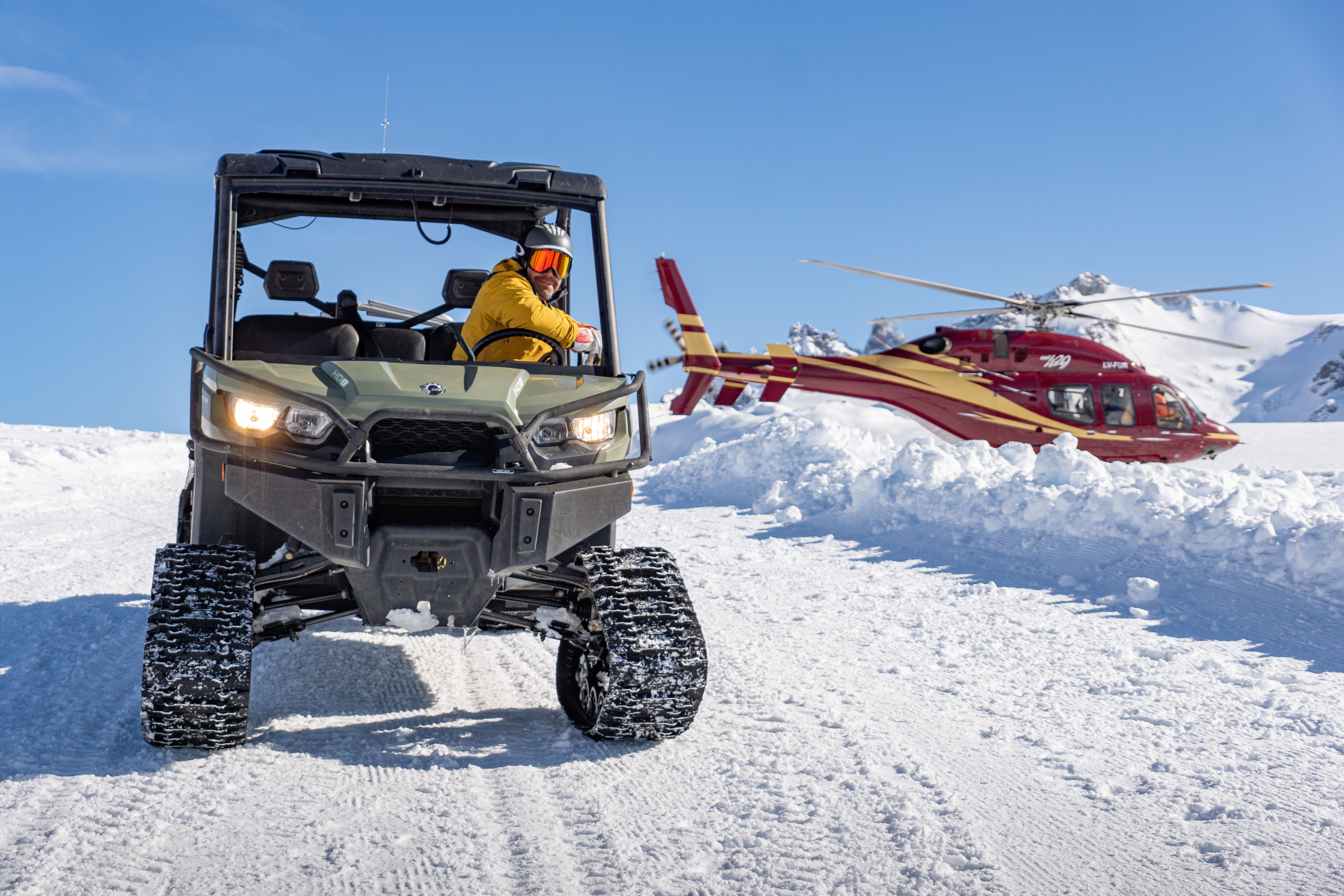 A Man Driving an Off Road Car in Snowy Mountains and a Helicopter ...