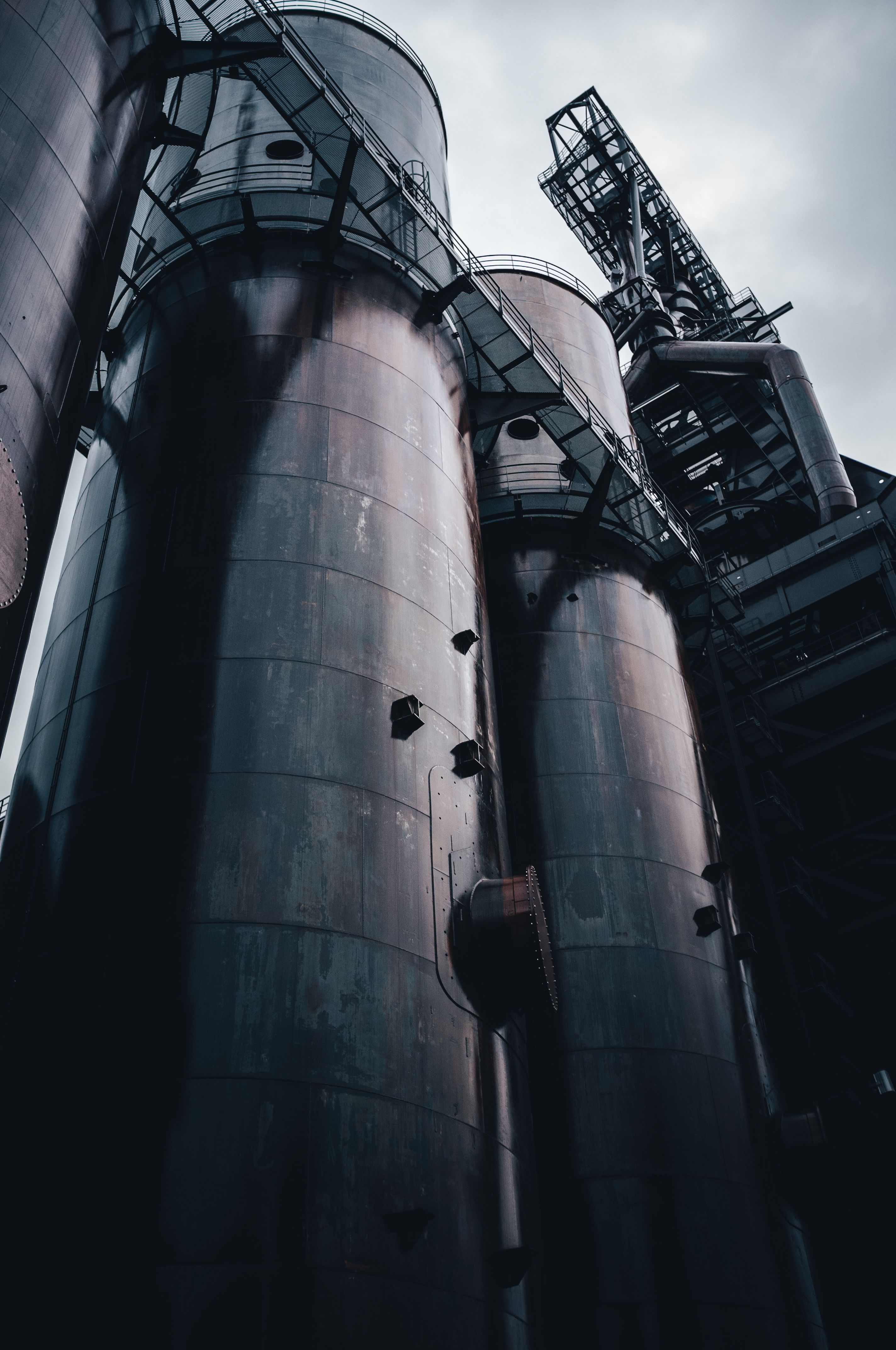 Low Angle Shot of Silos and a Metal Construction · Free Stock Photo
