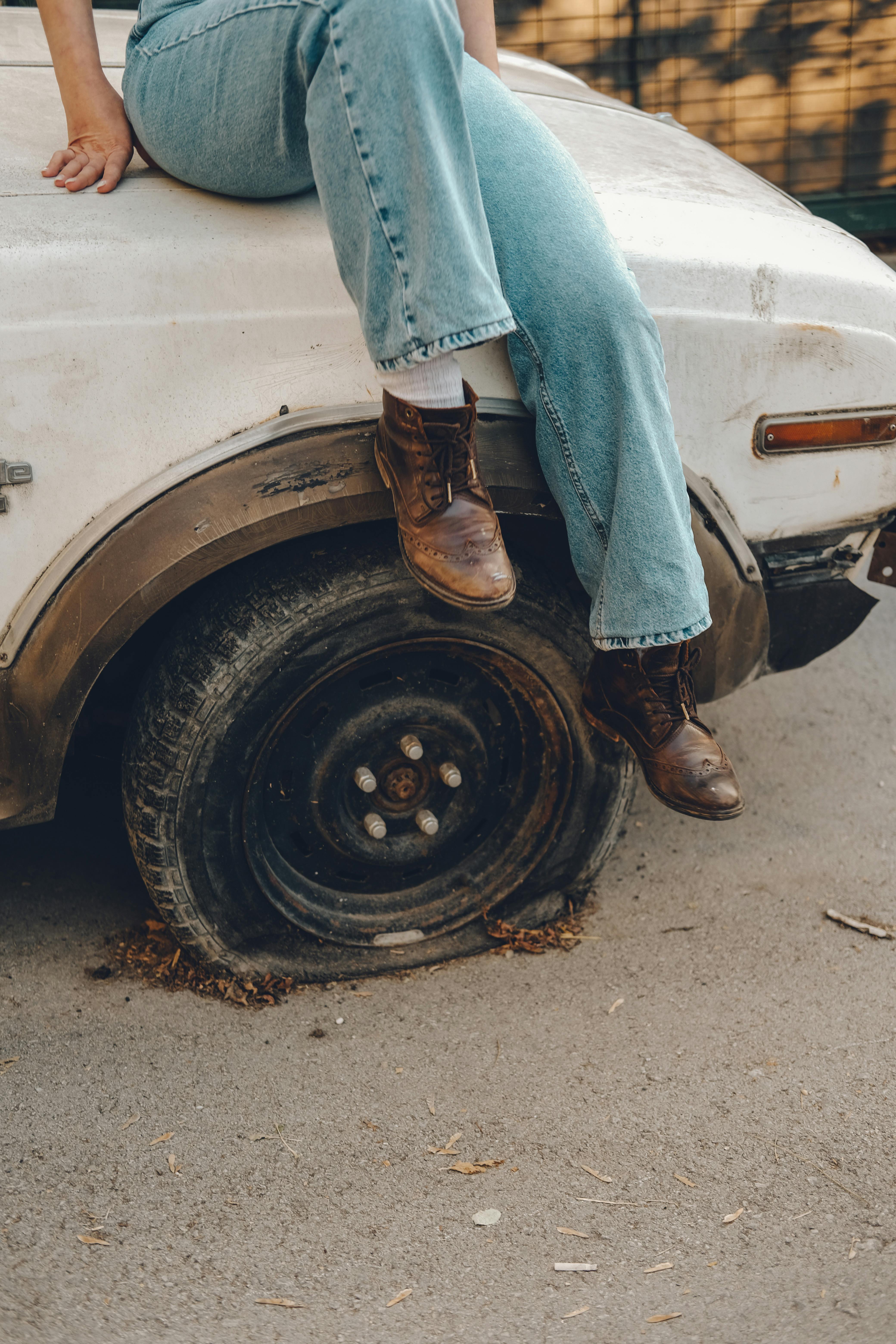 Bottom Half View of Person Sitting on an Old Cars Hood · Free Stock Photo