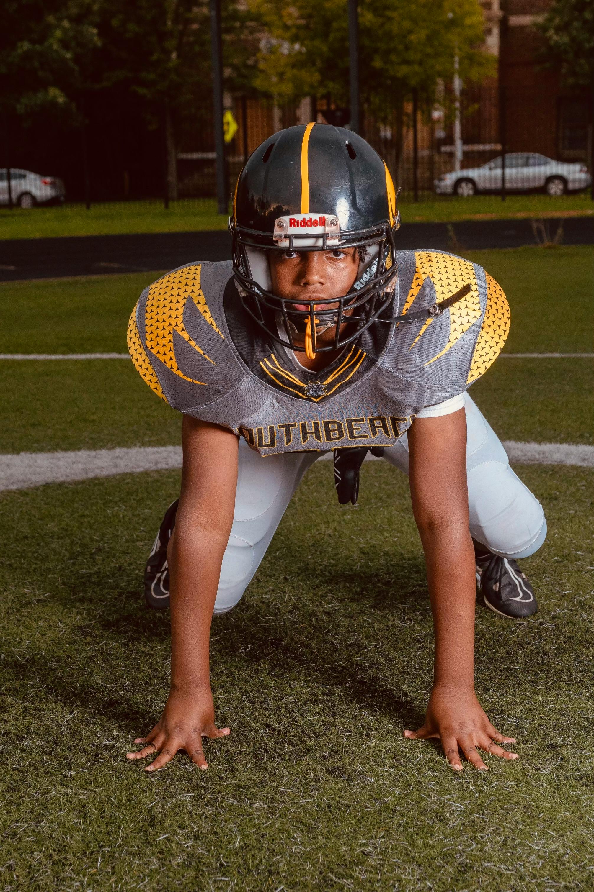 American Football Player in Full Gear Posing on the Field · Free Stock ...
