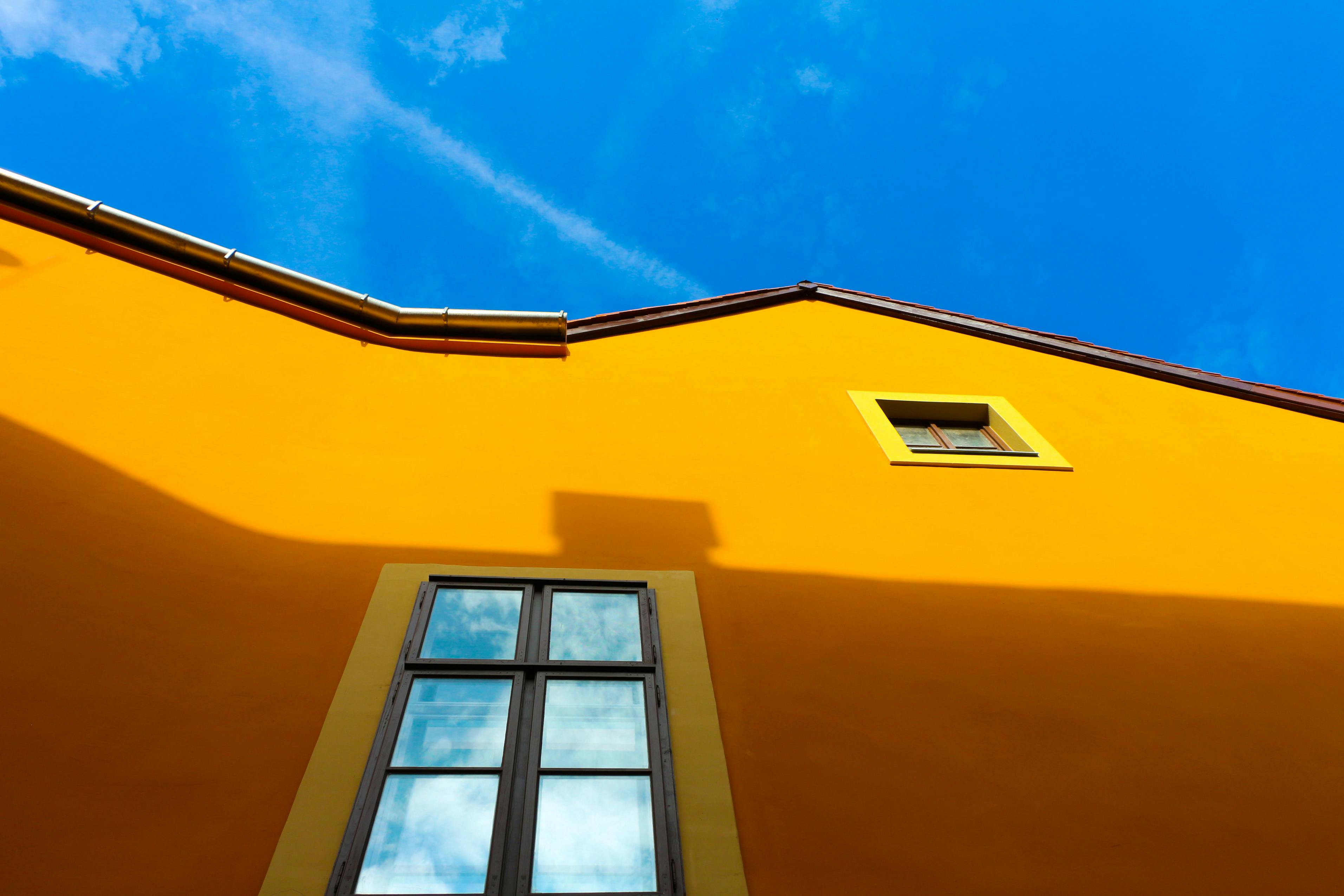 Facade of a Yellow Building with Black Window Frames · Free Stock Photo