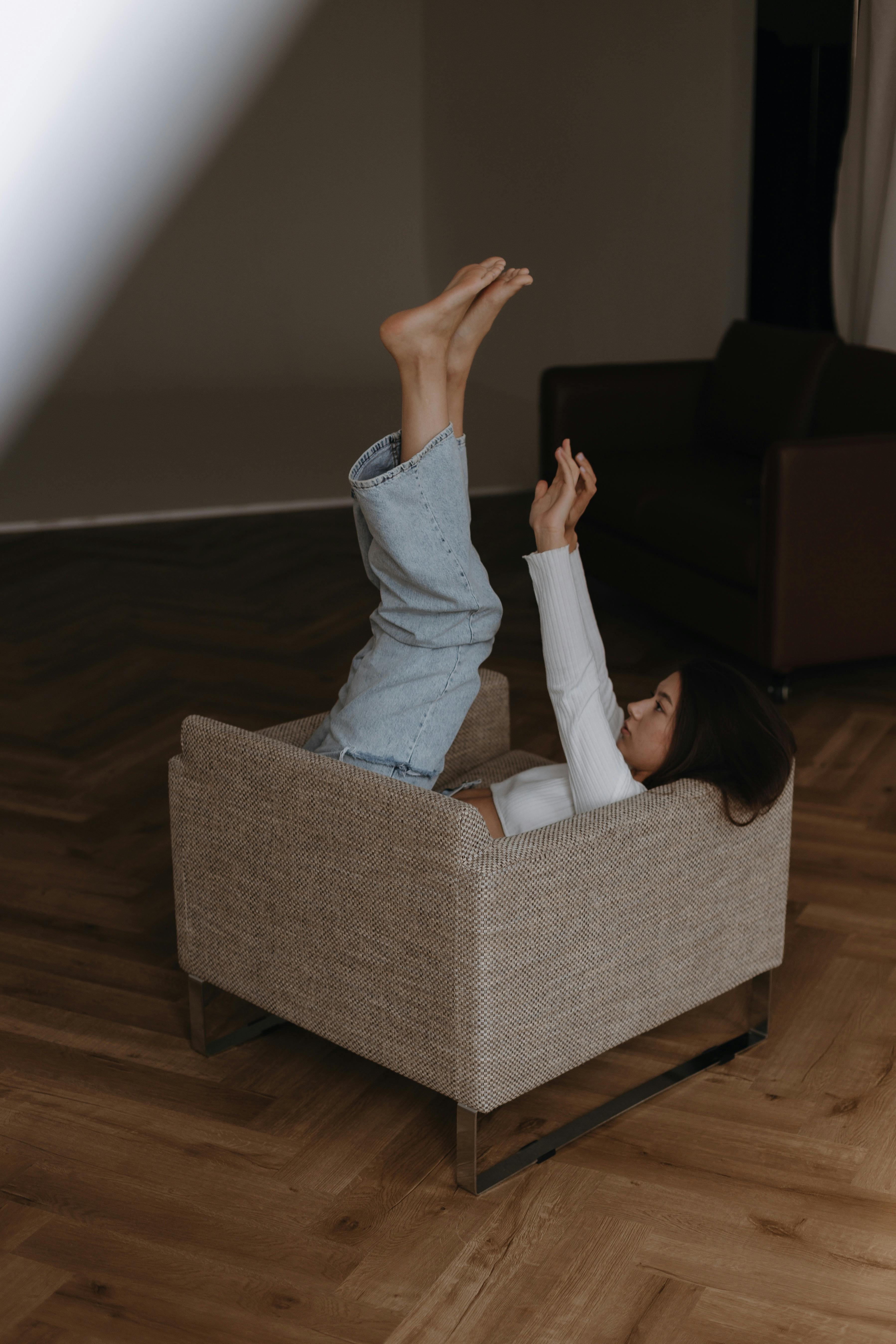 A Woman Stretching her Body in an Armchair · Free Stock Photo