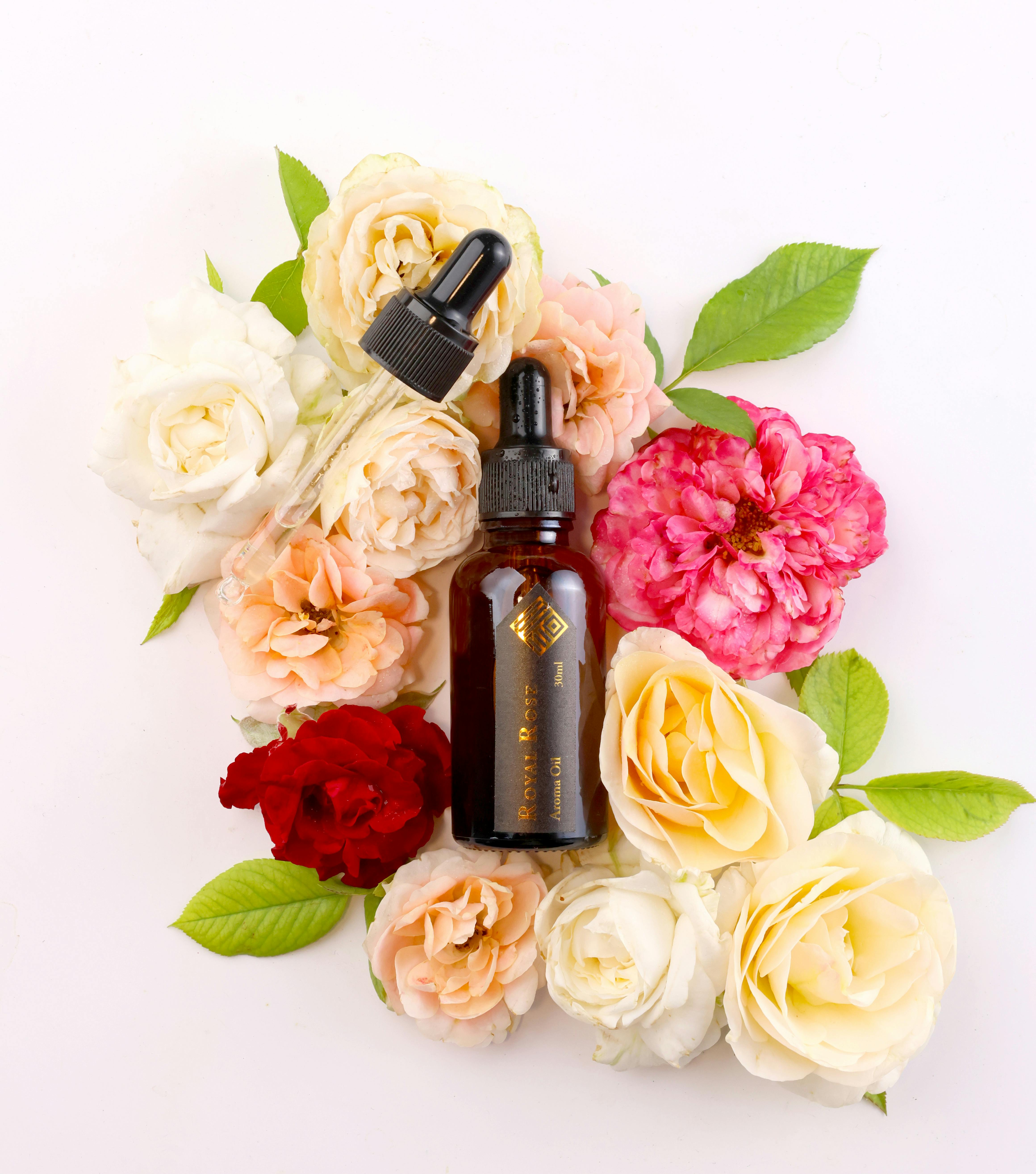Royal Rose Aroma Oil Dropper Bottle Among Flowers · Free Stock Photo