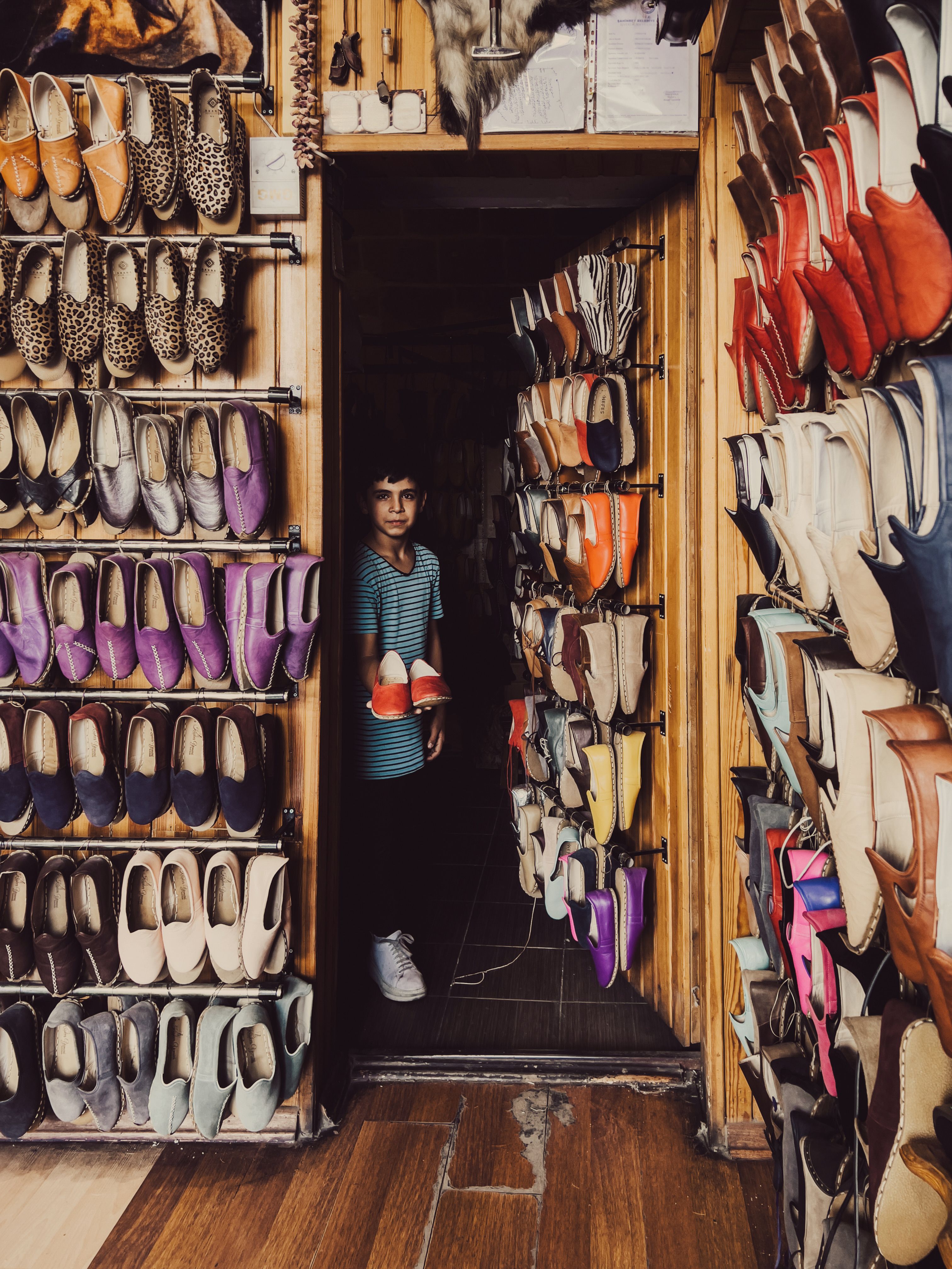 Boy Walking into Room Lined with Shoes · Free Stock Photo