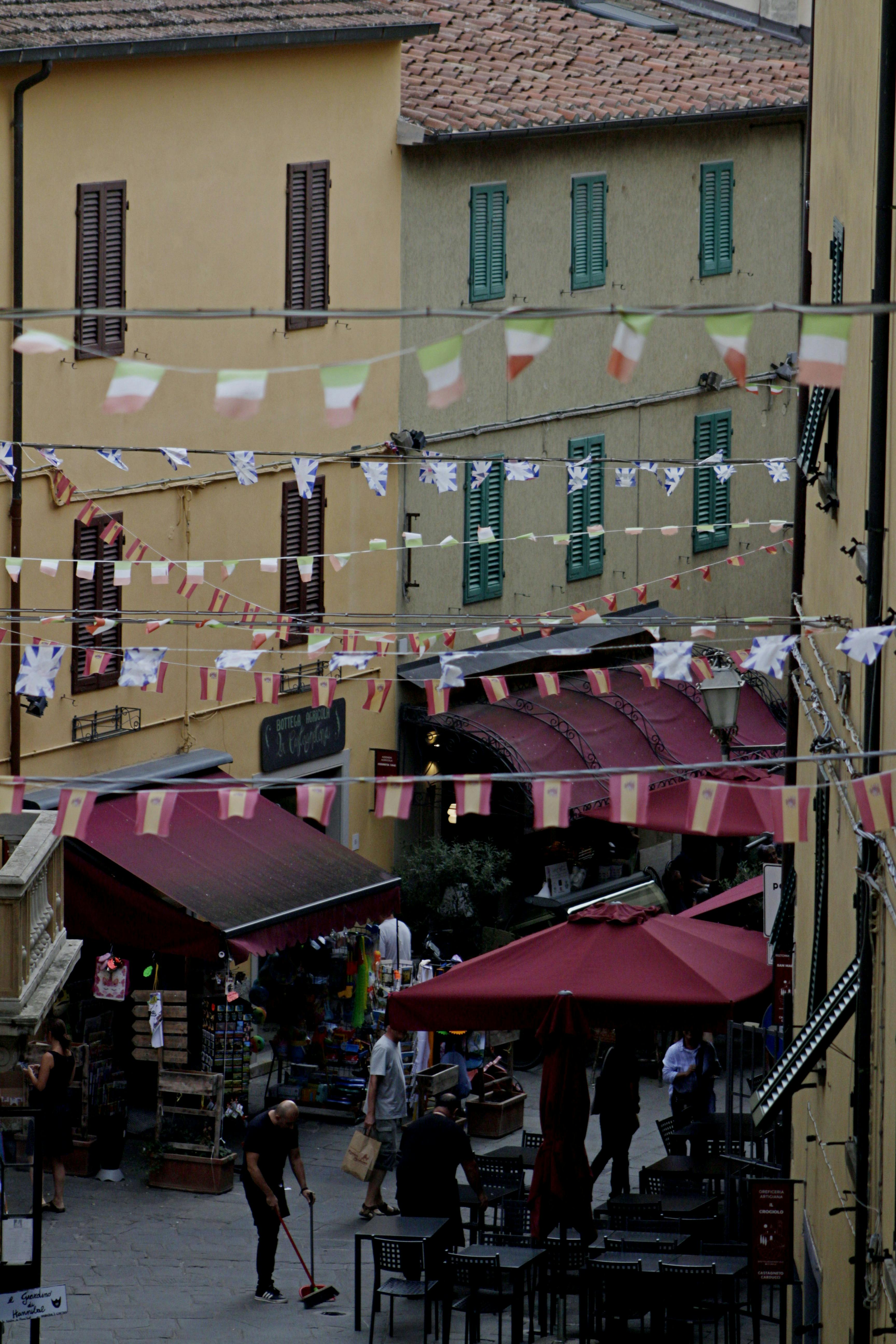 Bunting Flags Over an Alley with Restaurants · Free Stock Photo