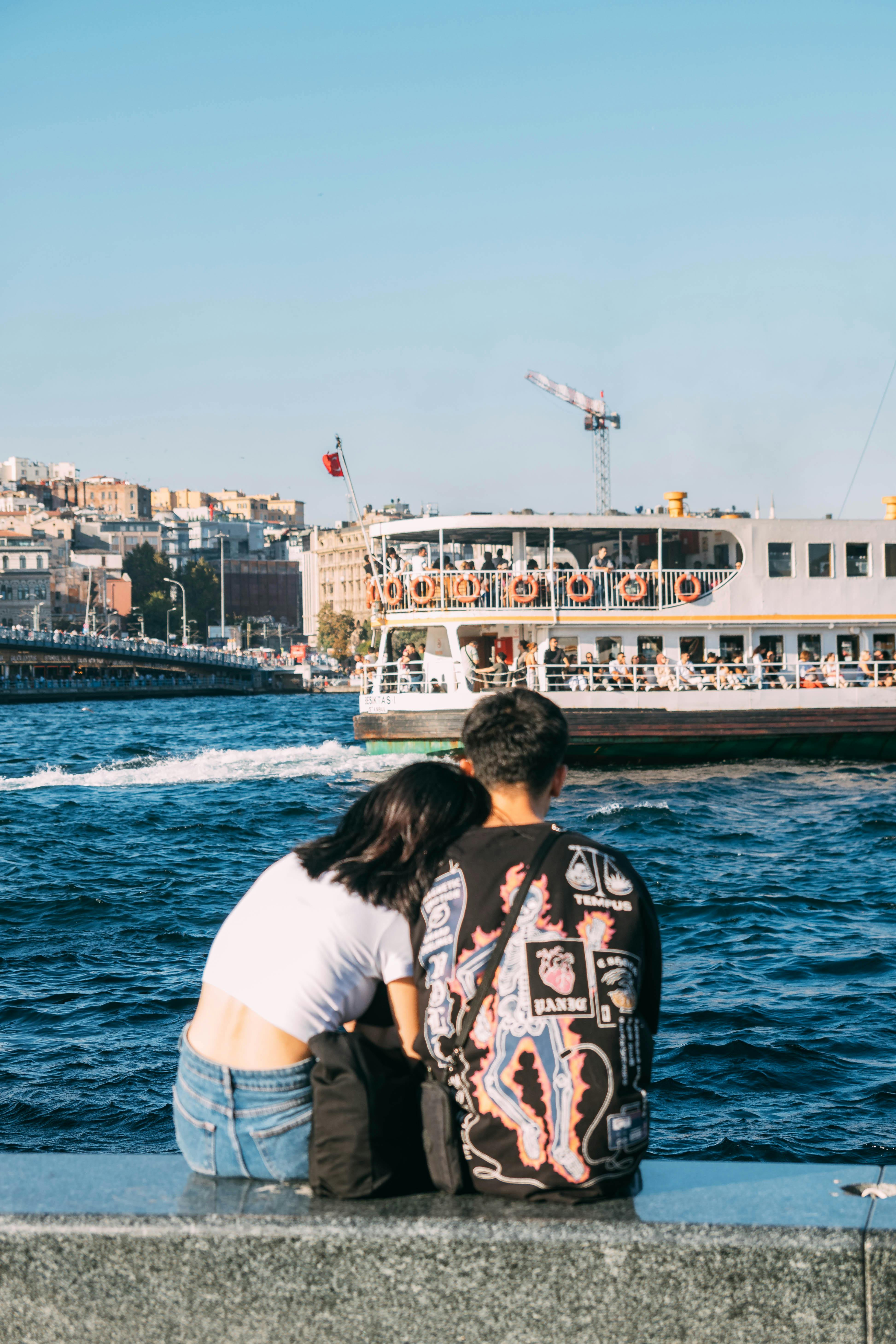 Back View of a Couple Sitting on the Shore of the Bosphorus Strait ...