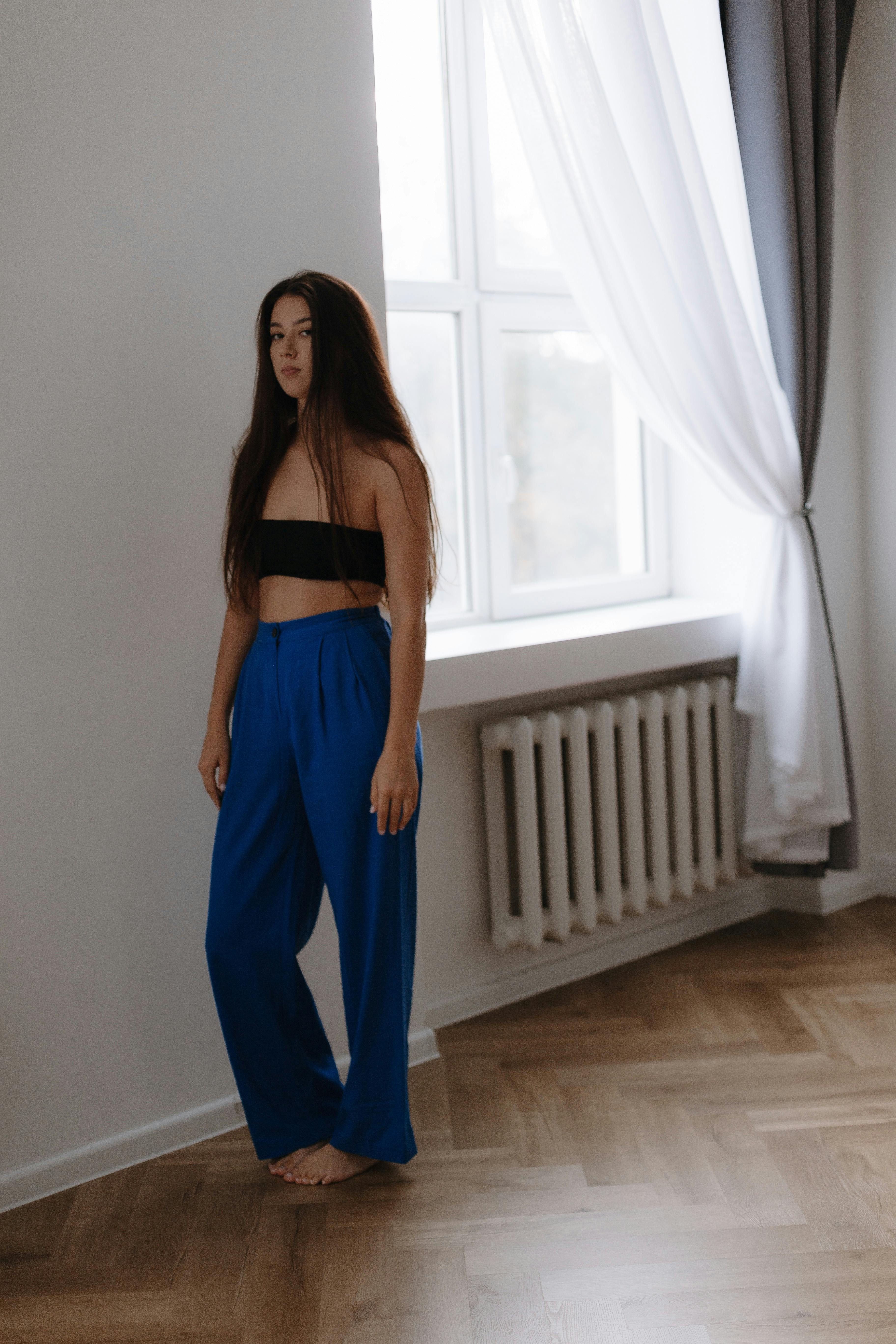 Young Woman Wearing Blue Pants Posing in Studio · Free Stock Photo