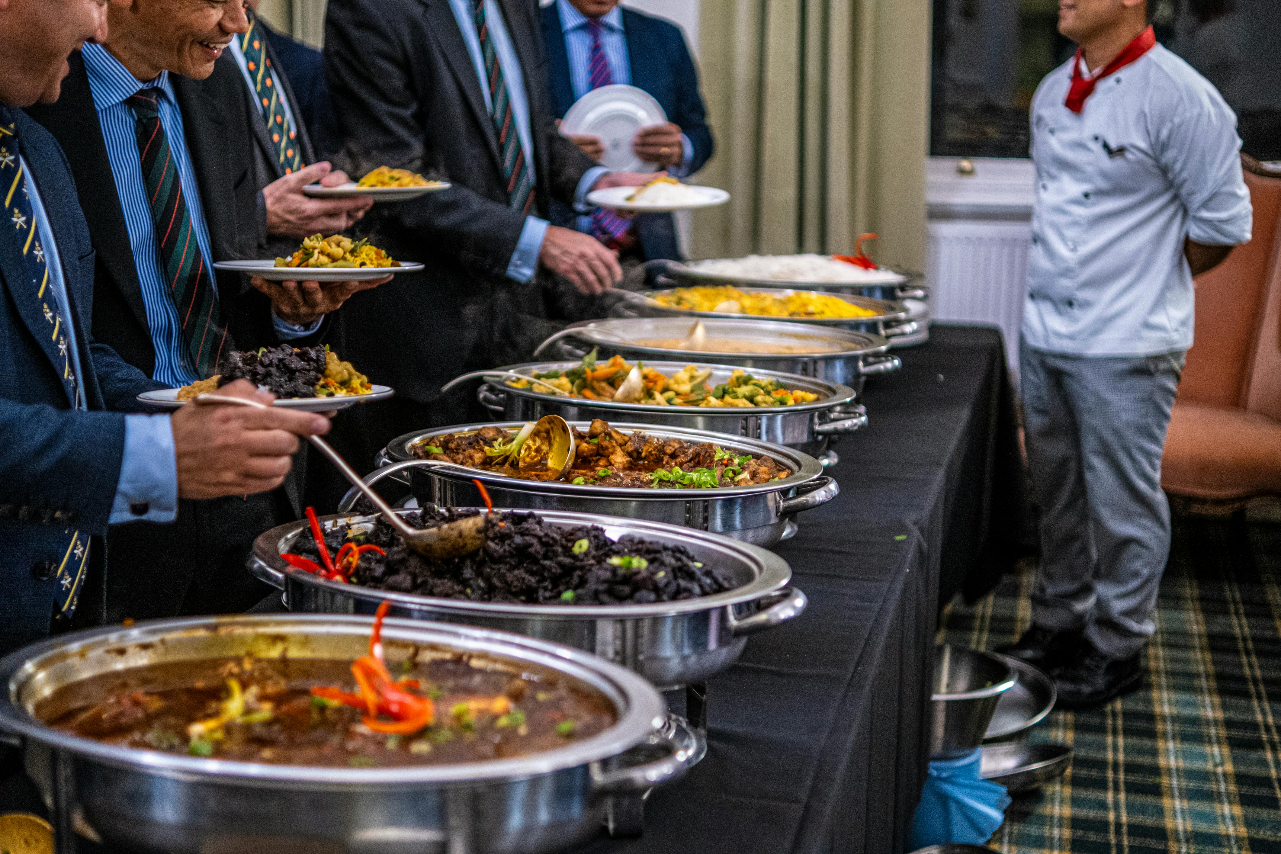 Men in Suits Choosing Food from Table · Free Stock Photo