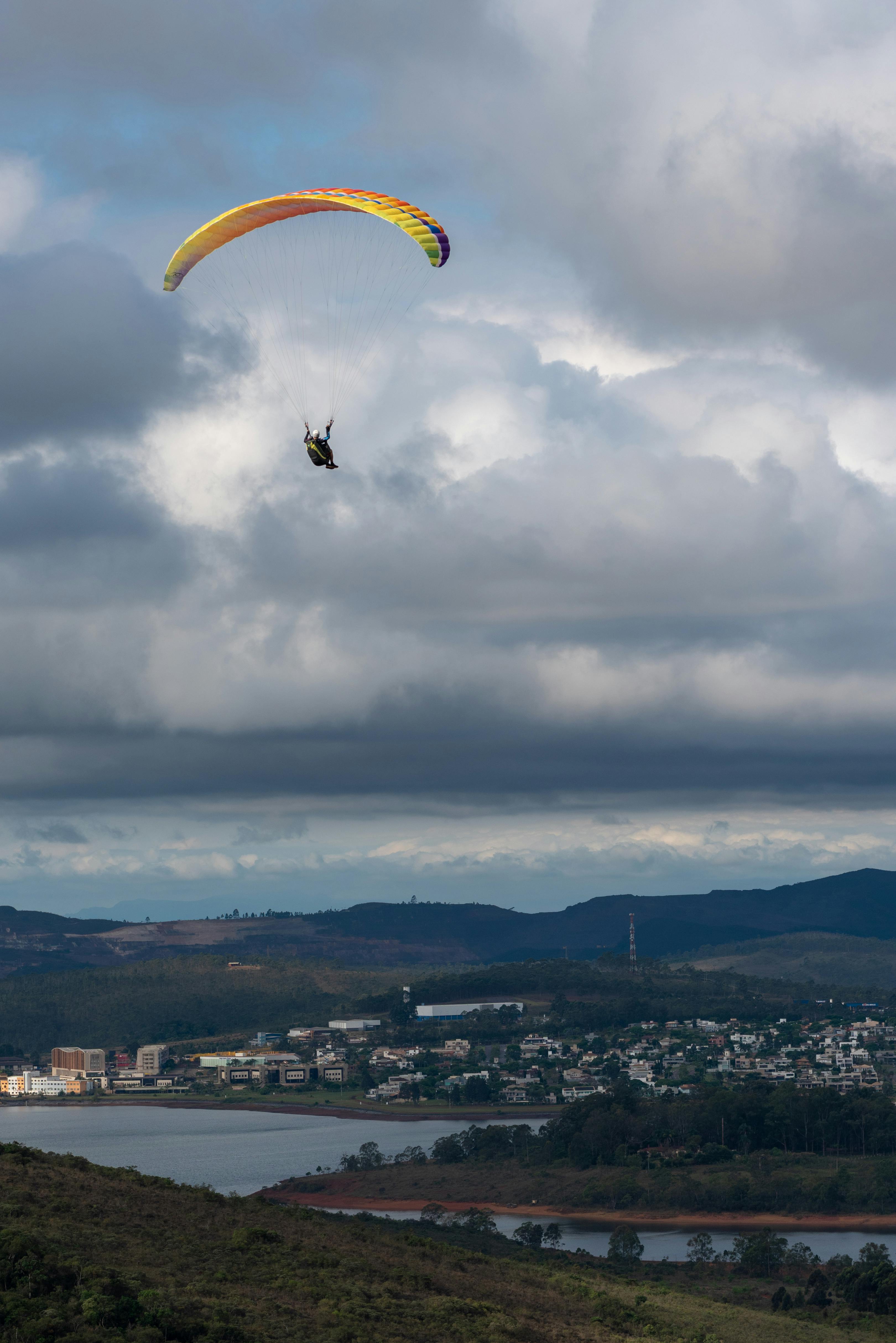 Parachuting over Hill and Lake · Free Stock Photo