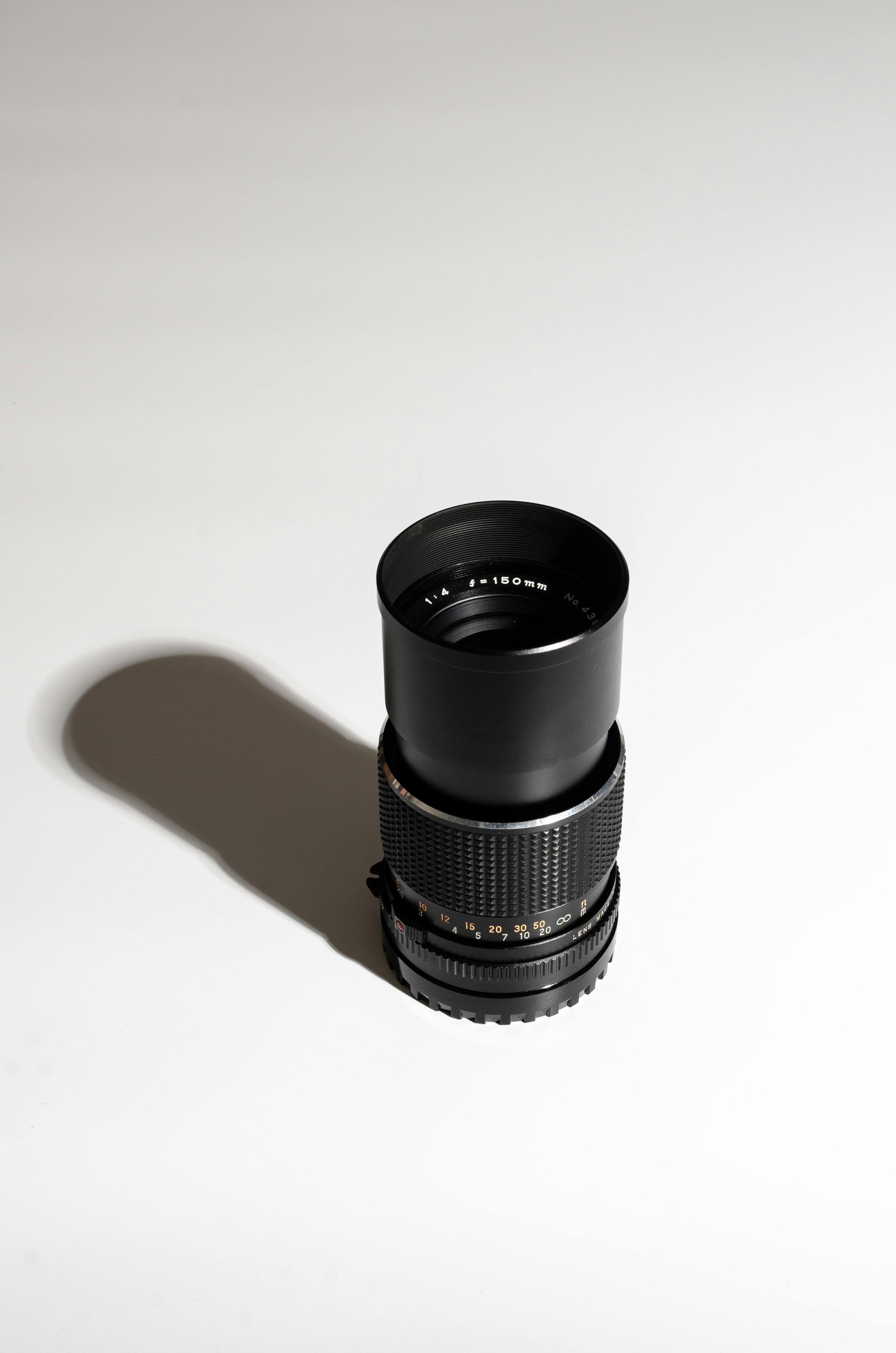 Black Camera Lens Stands on White · Free Stock Photo