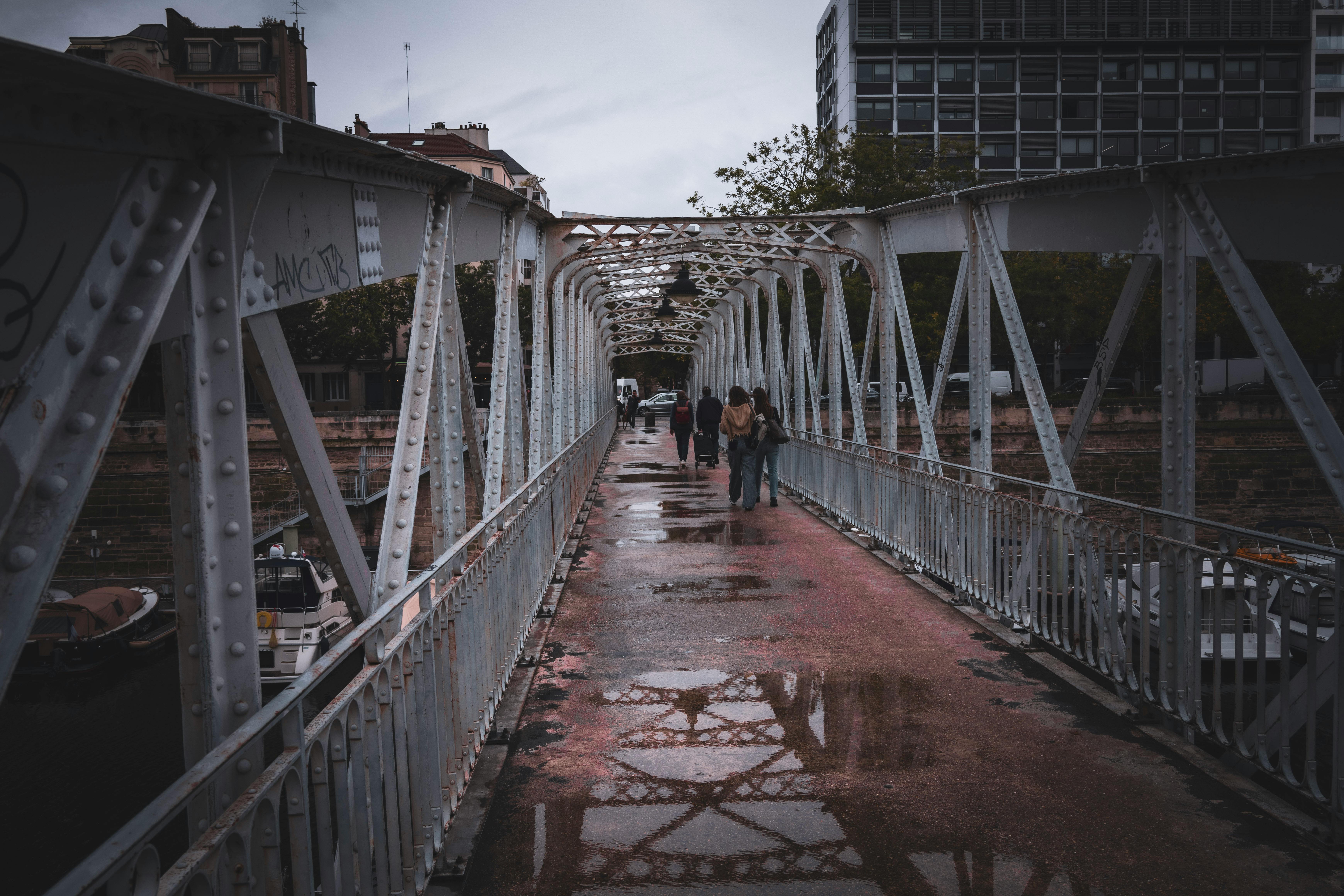 People Walking on Metal Pedestrian Bridge after Rain · Free Stock Photo
