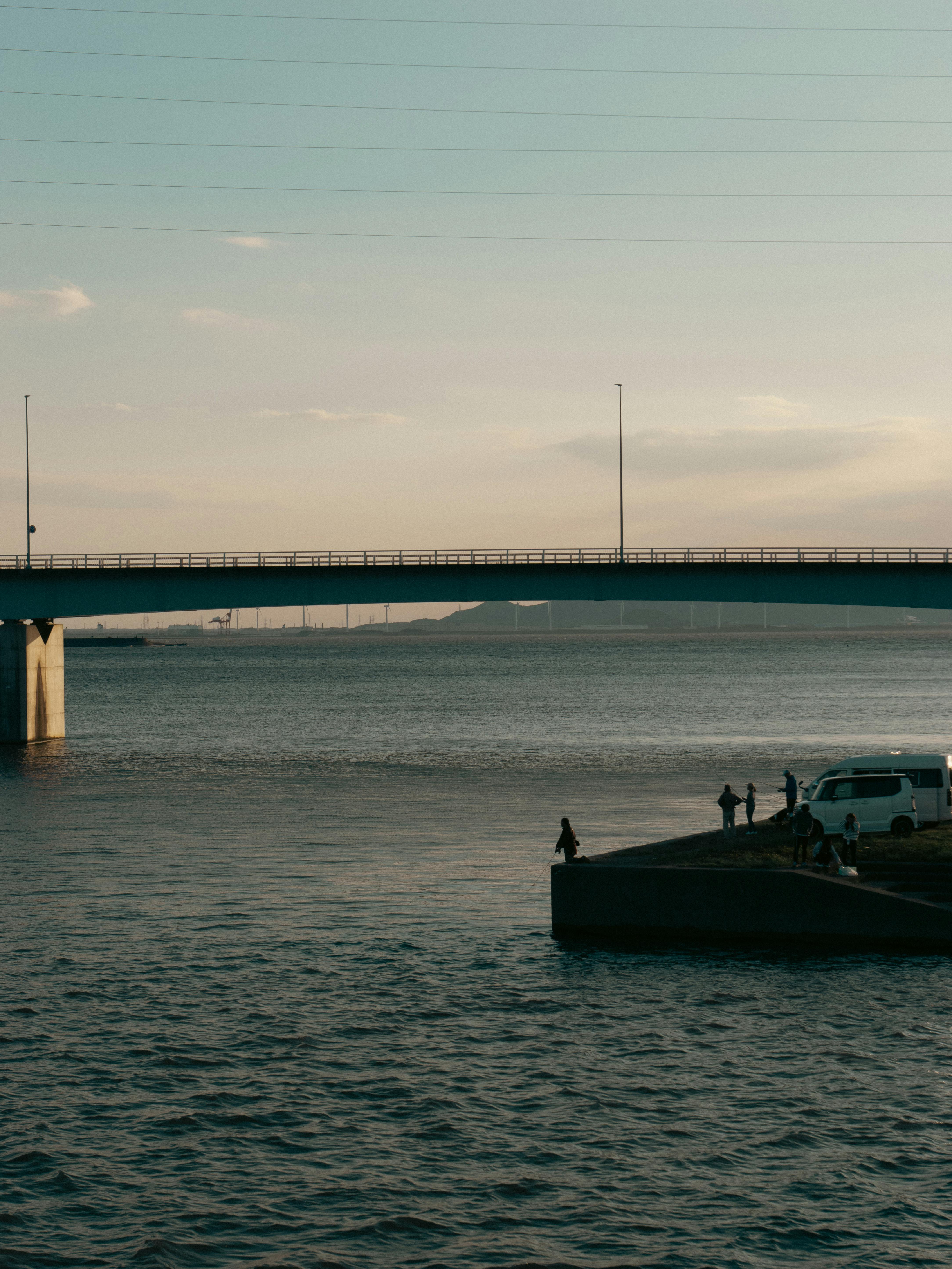 Men Standing on Waterfront near to Bridge · Free Stock Photo