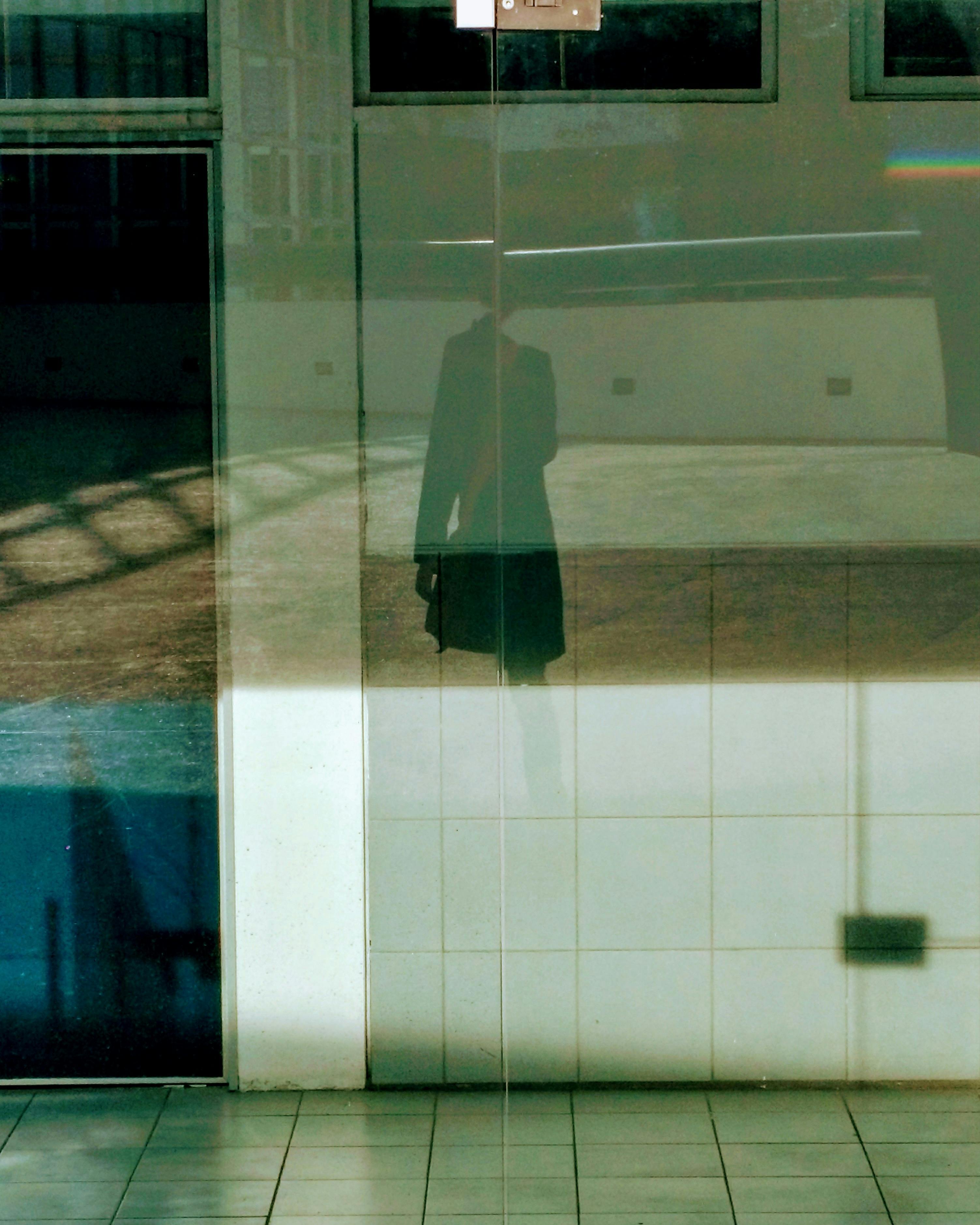 Reflection of Walking Person on Wall · Free Stock Photo