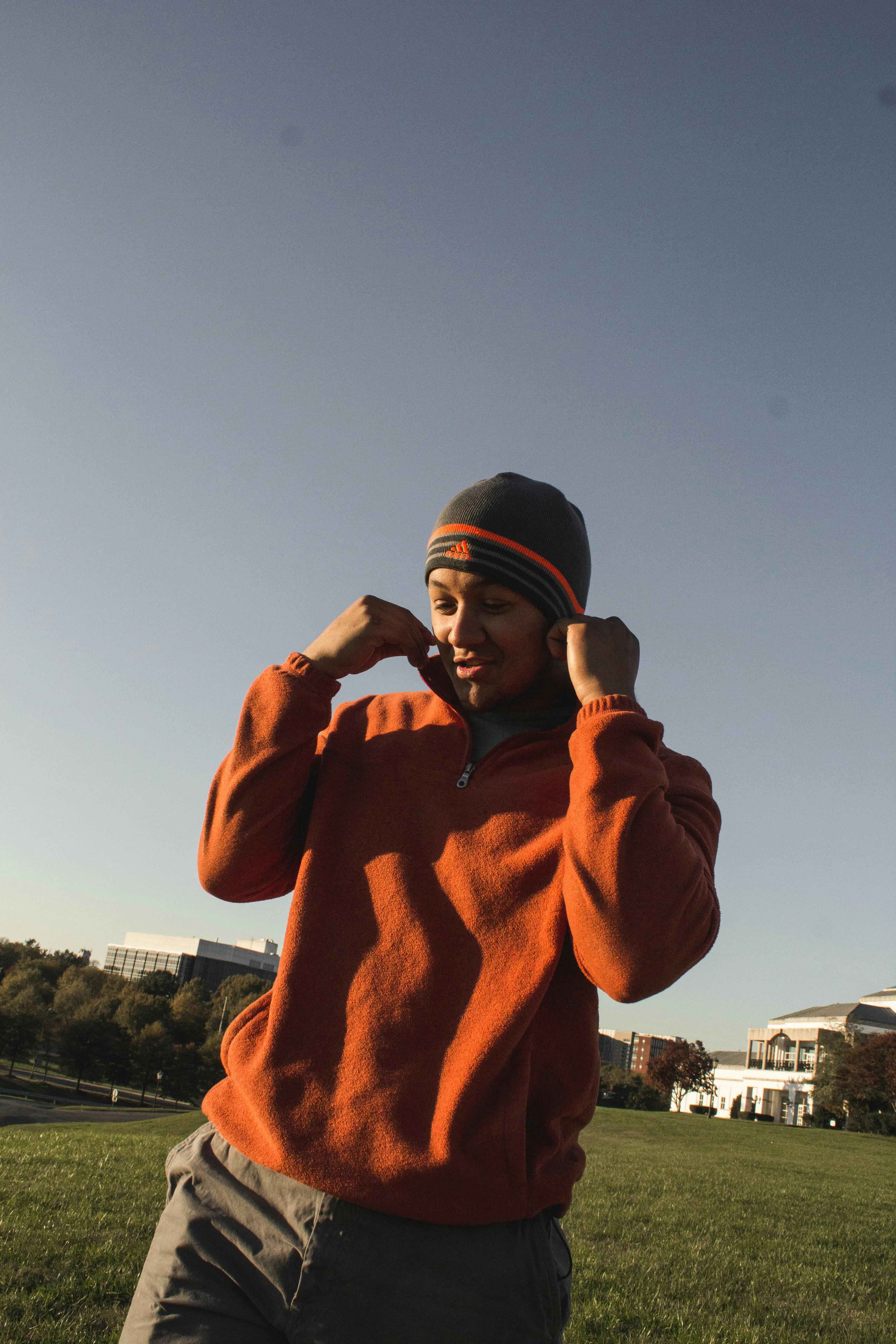 Smiling Man Standing In Open Field Looking Down · Free Stock Photo