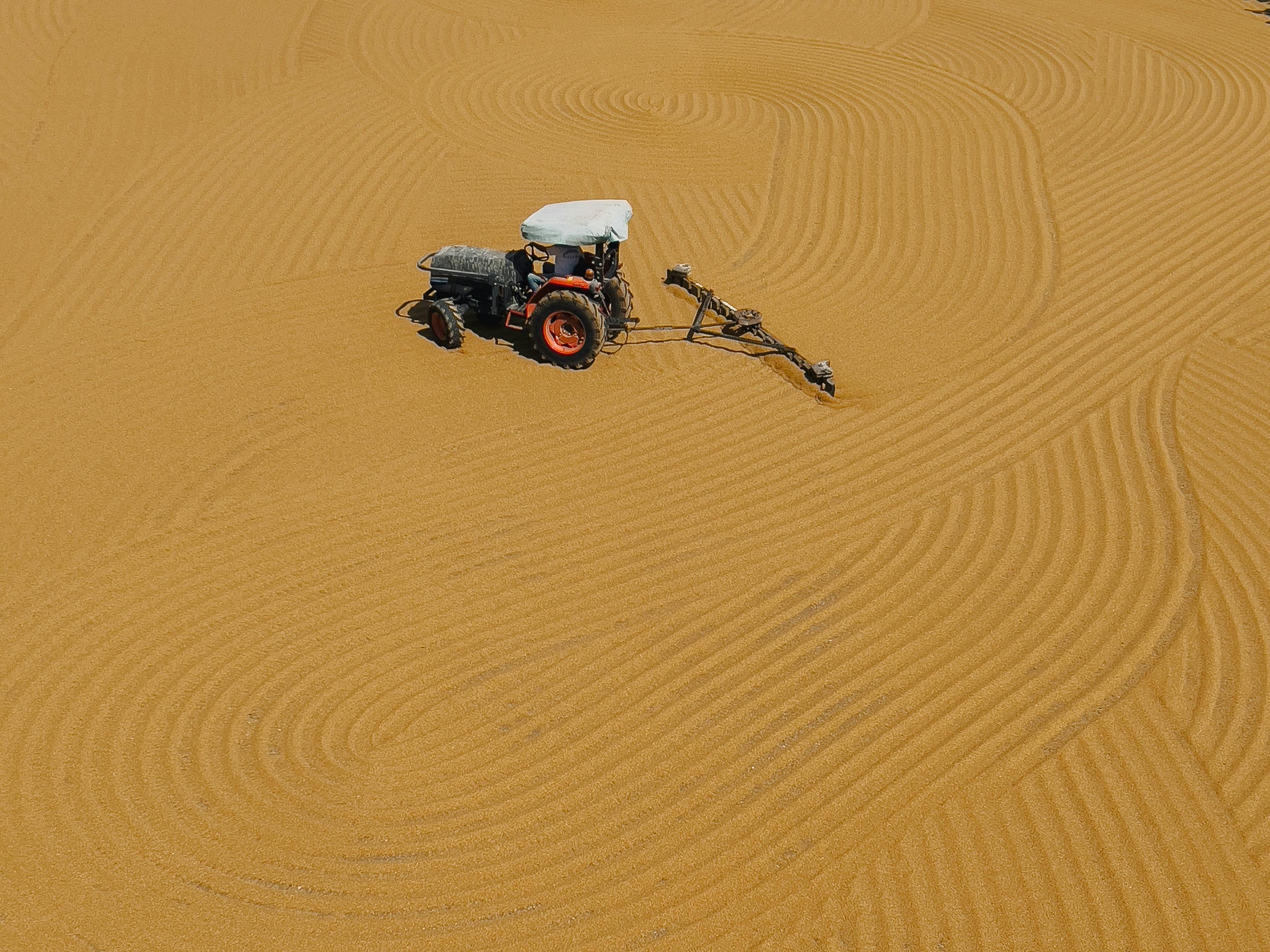 Aerial View of a Tractor Harrowing Sand · Free Stock Photo
