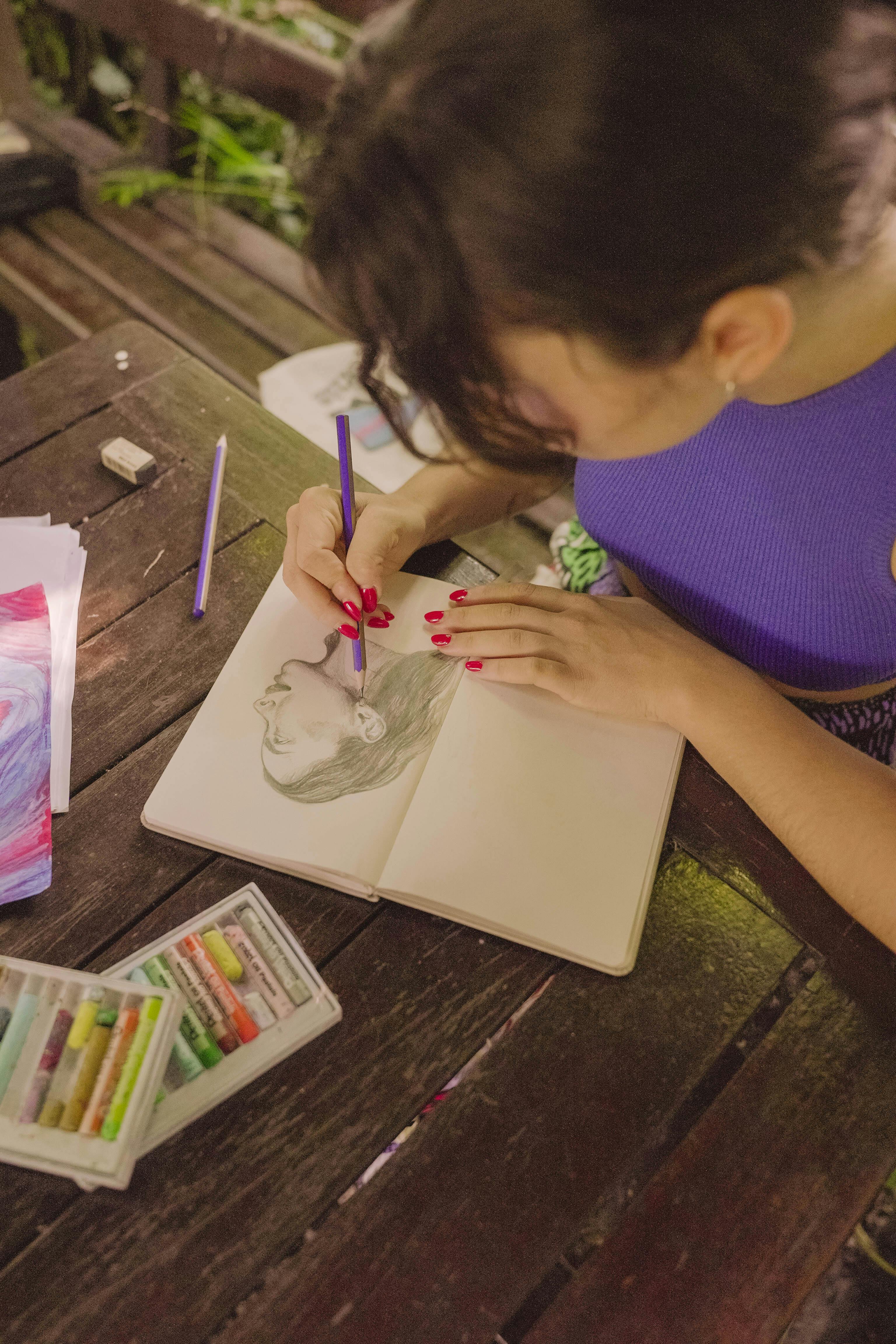 Woman Drawing in Notebook · Free Stock Photo