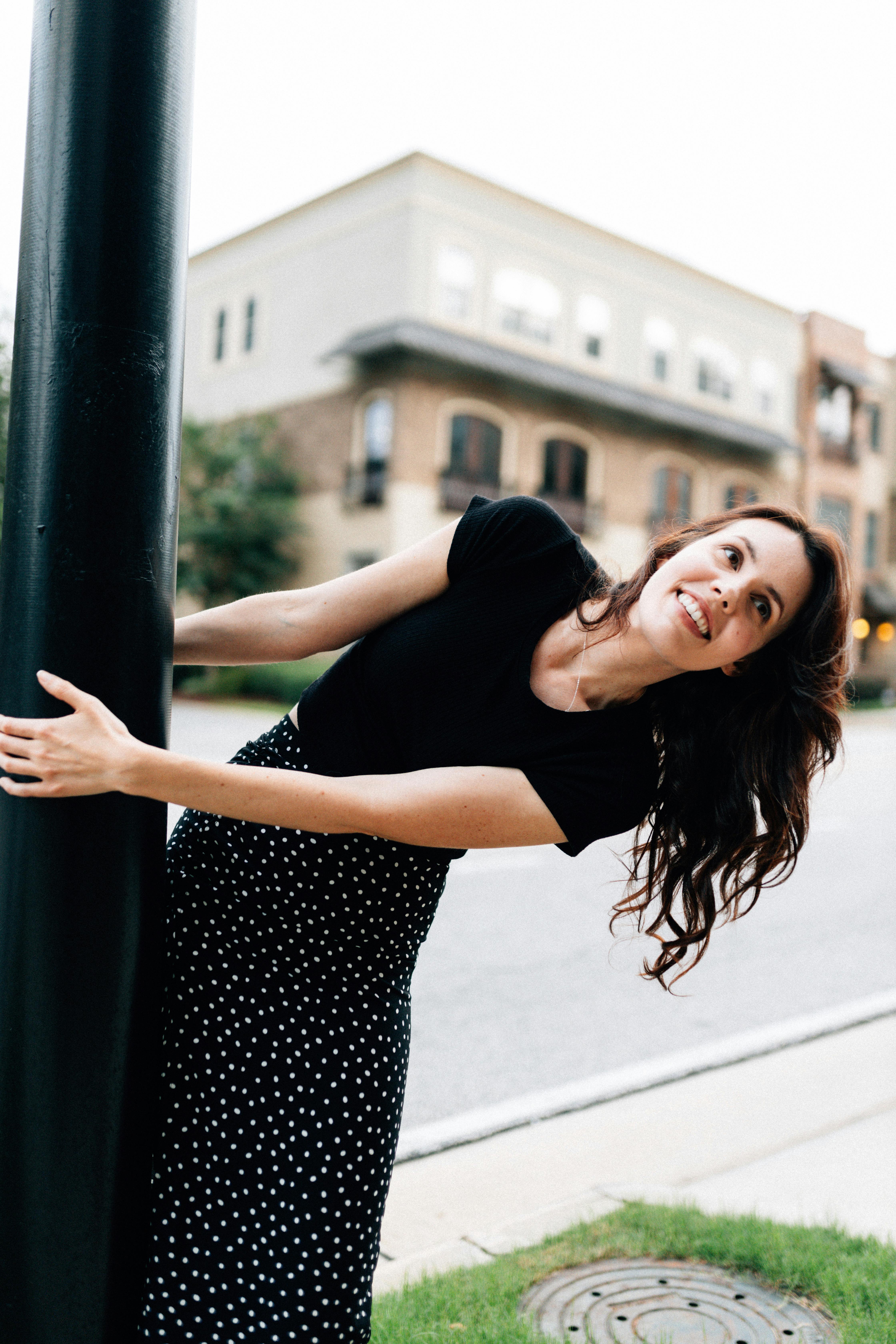 Smiling Woman Leaning on Pole · Free Stock Photo