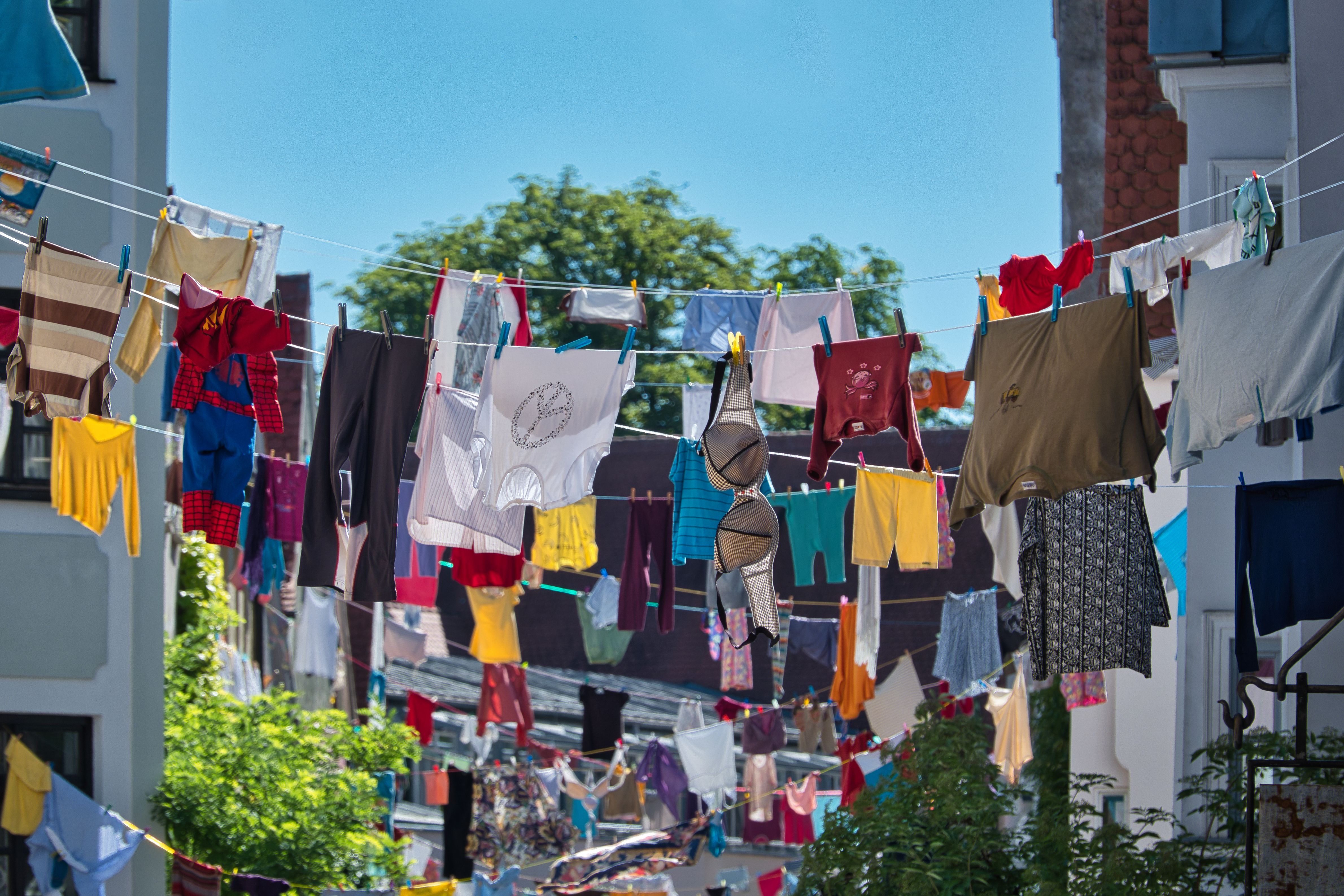 Laundry Hung over the Street Between Townhouses · Free Stock Photo