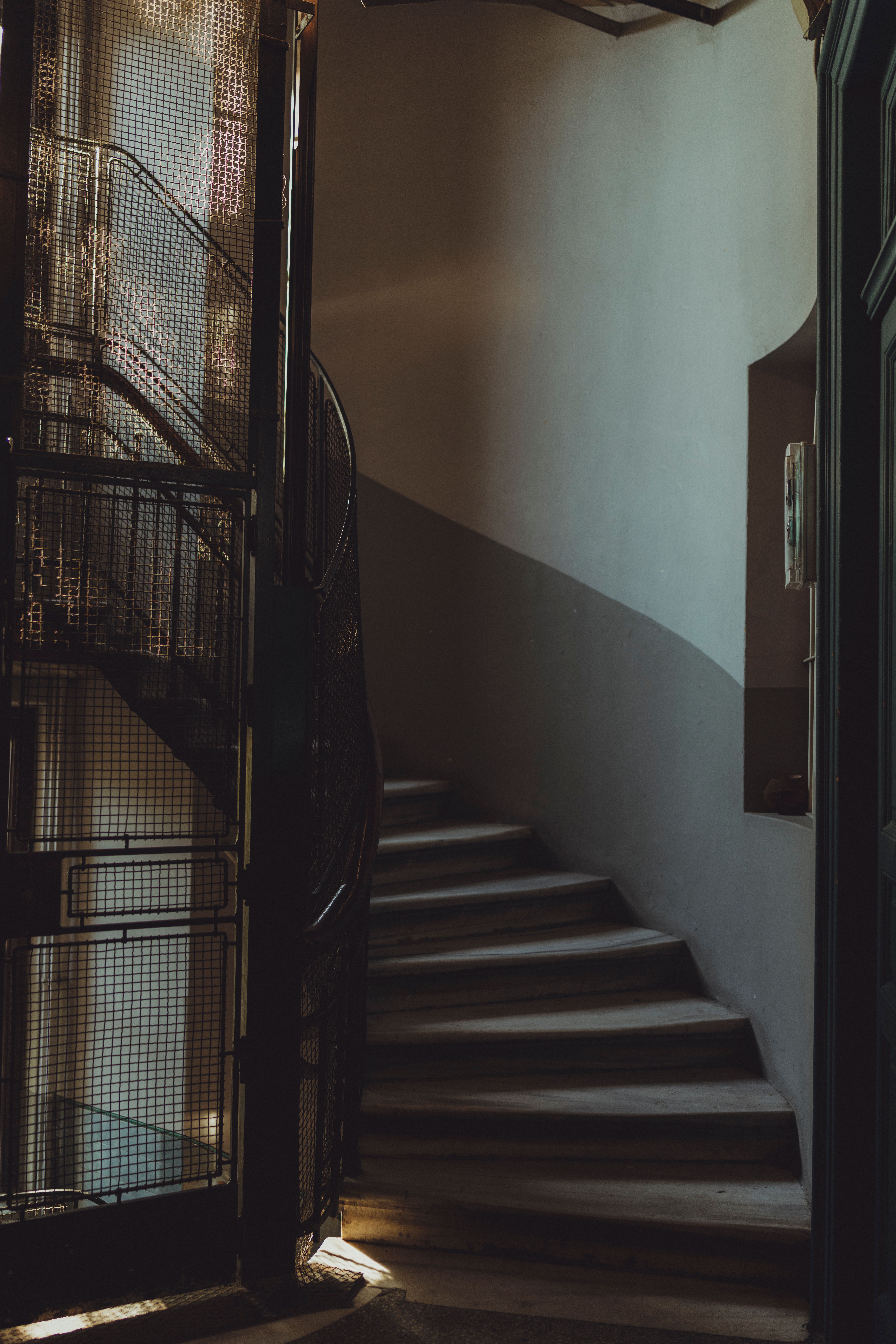 Spiral Staircase in the Stairwell and an Old Fashioned Elevator Cage ...