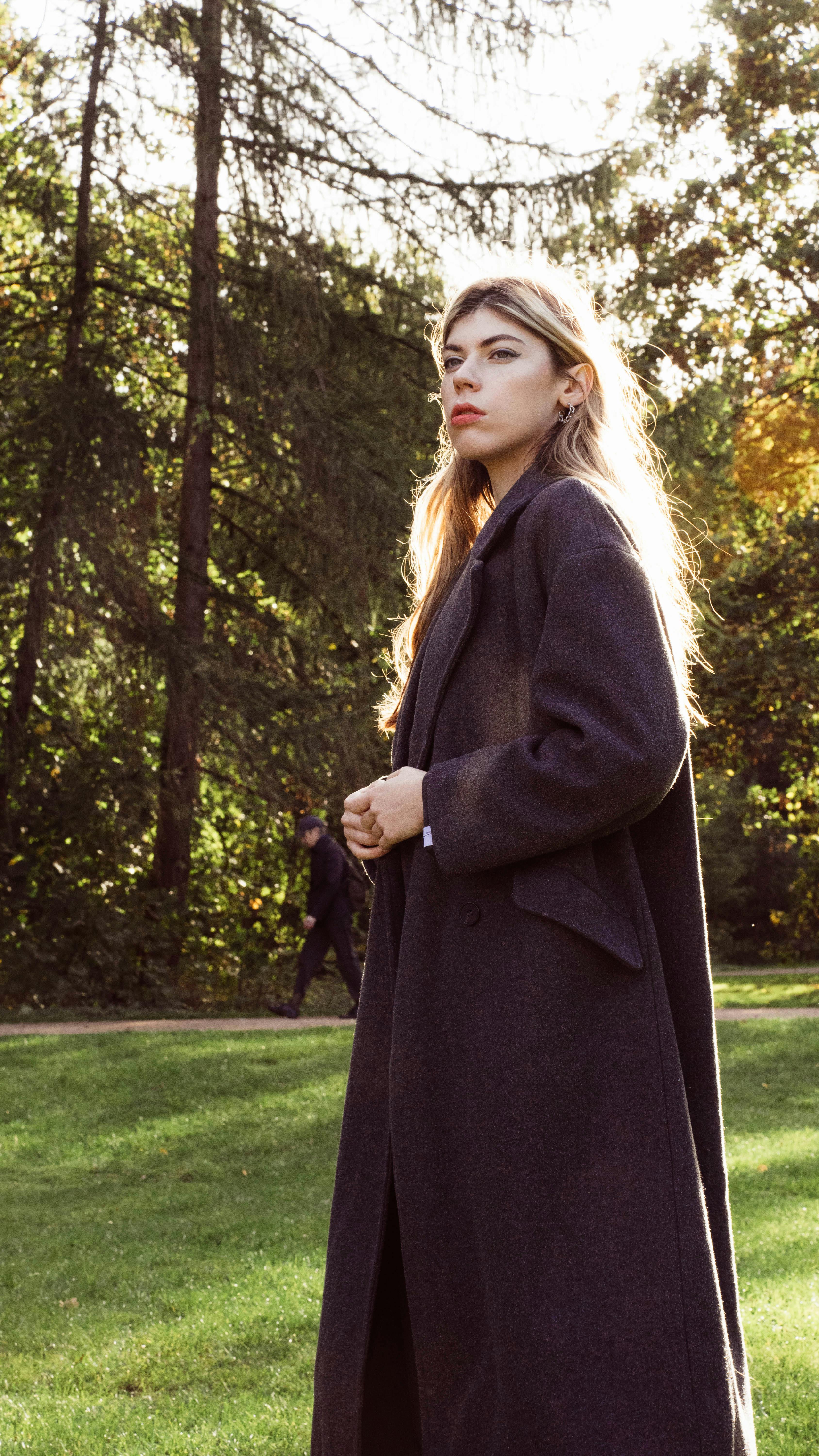 Model in Long Black Coat in Park · Free Stock Photo