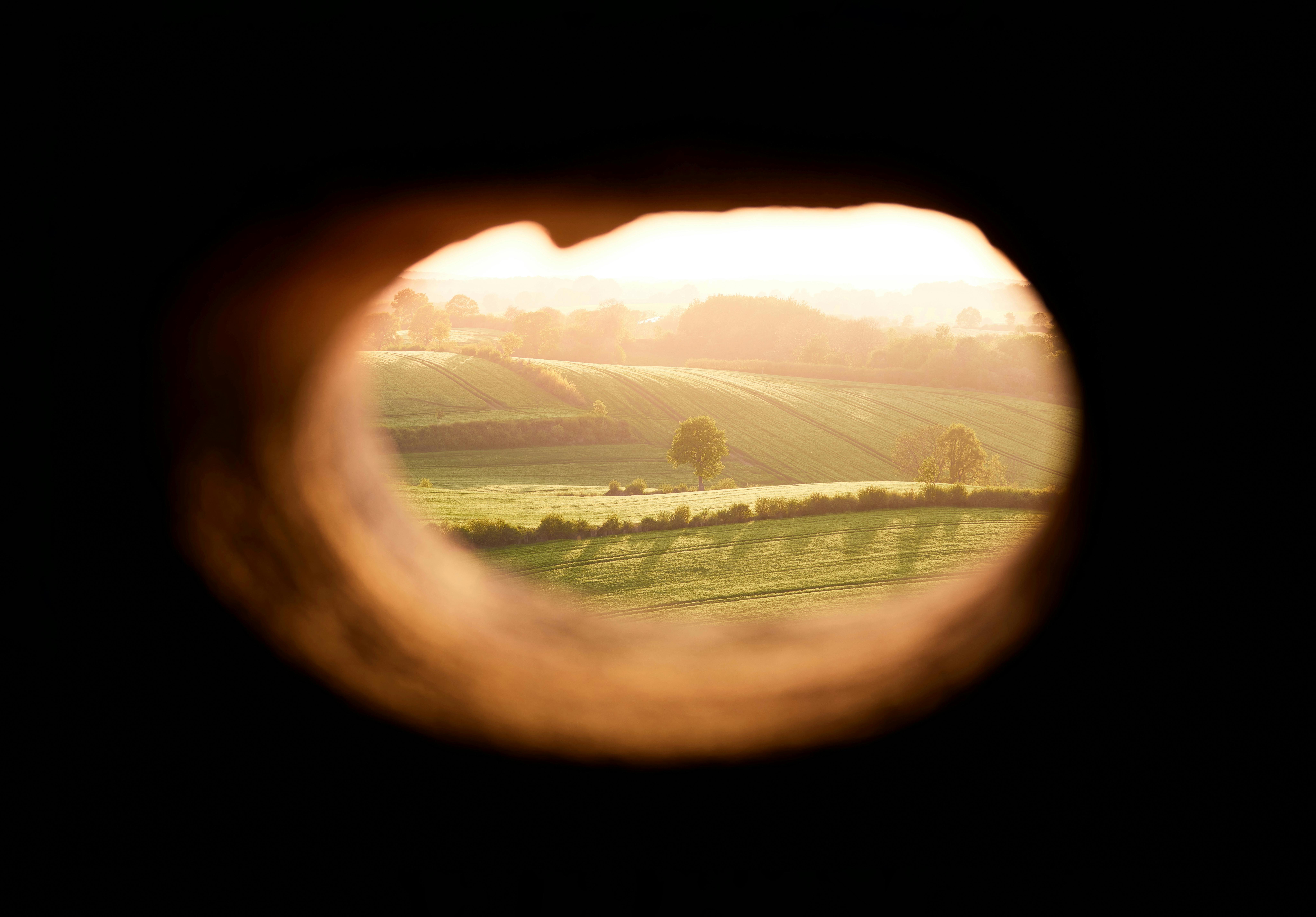 View of Green Fields through a Hole in a Wall · Free Stock Photo