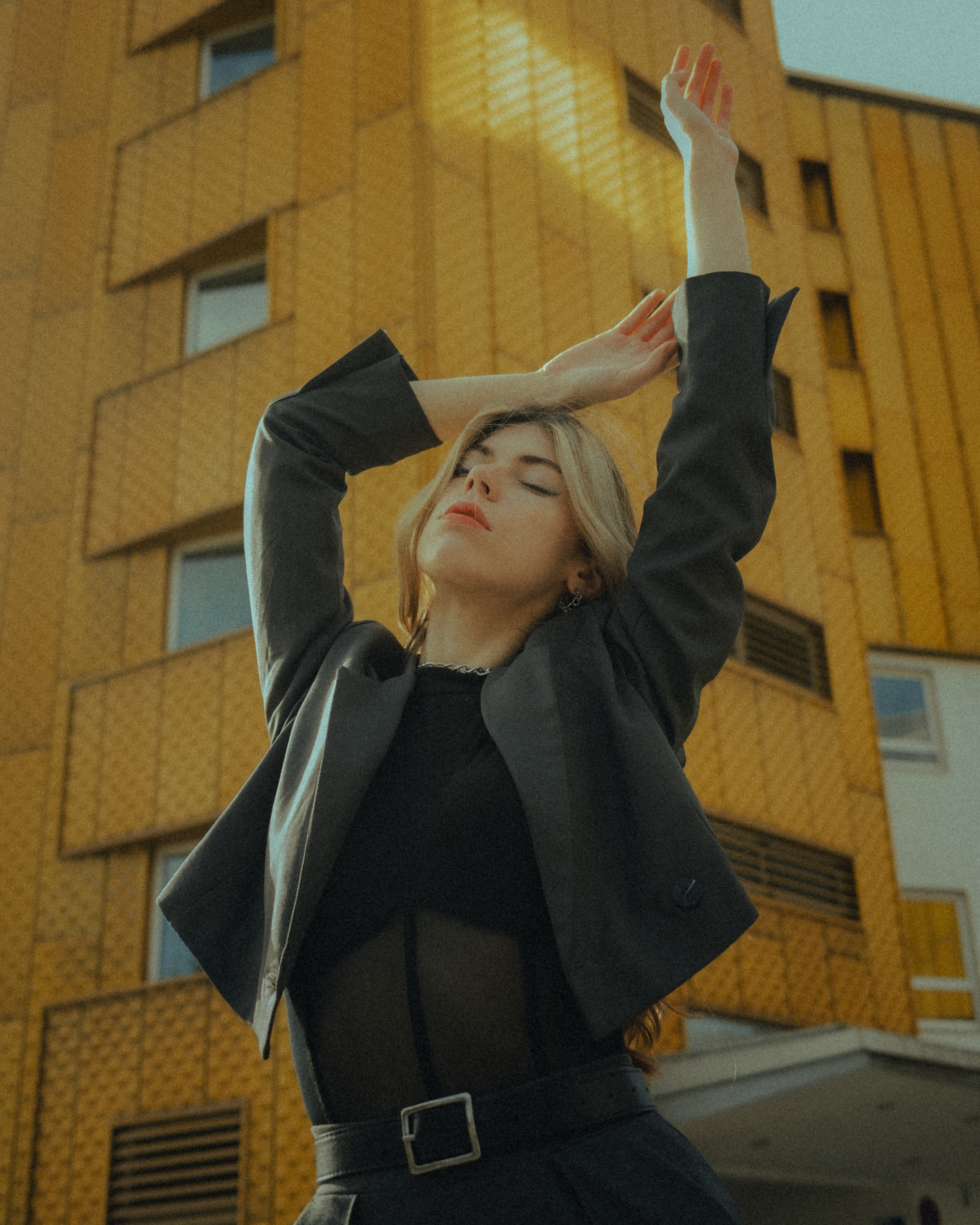 Blonde Woman in Suit Jacket and with Arms Raised · Free Stock Photo