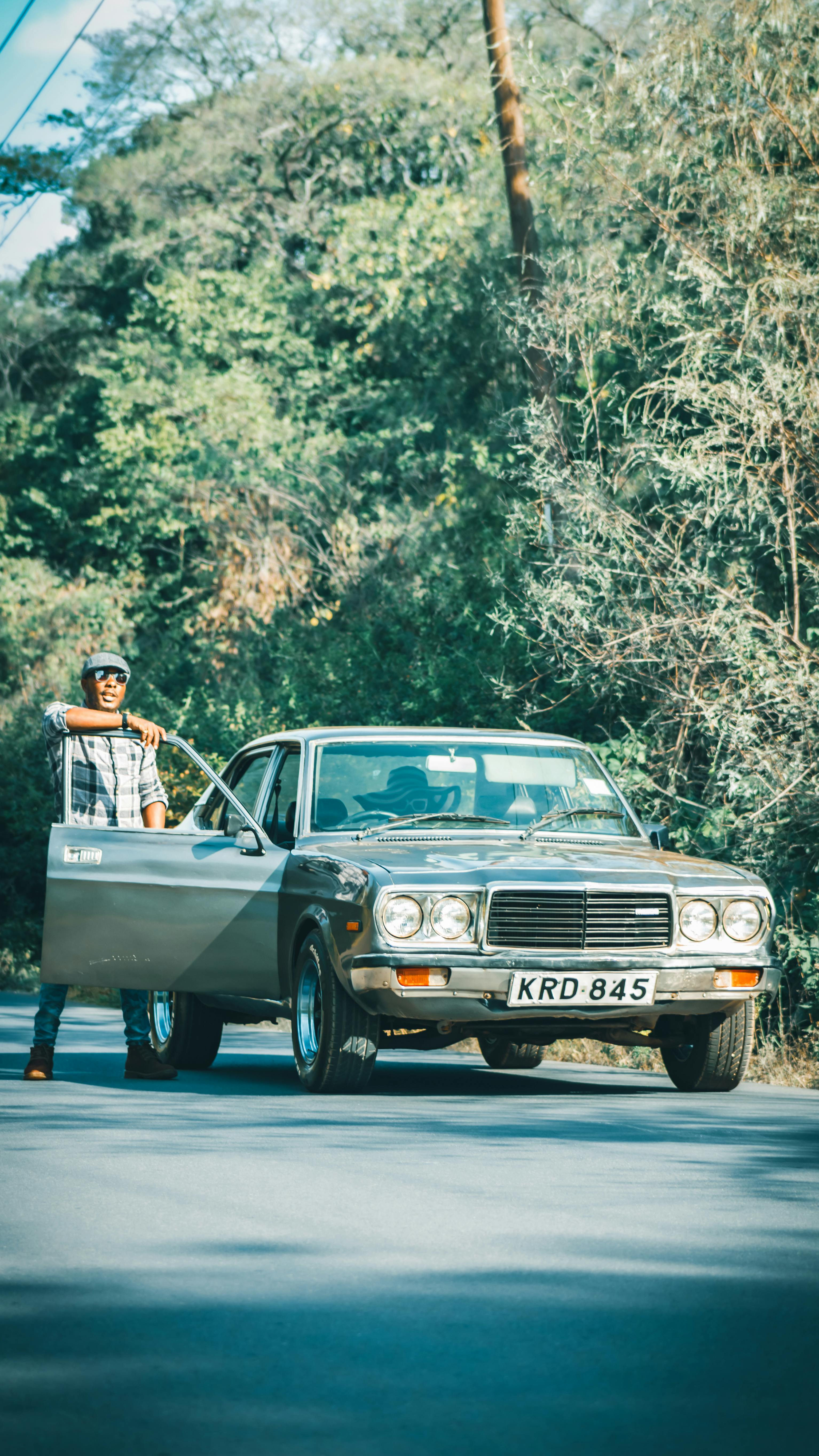 People Riding in Retro Car on City Road · Free Stock Photo