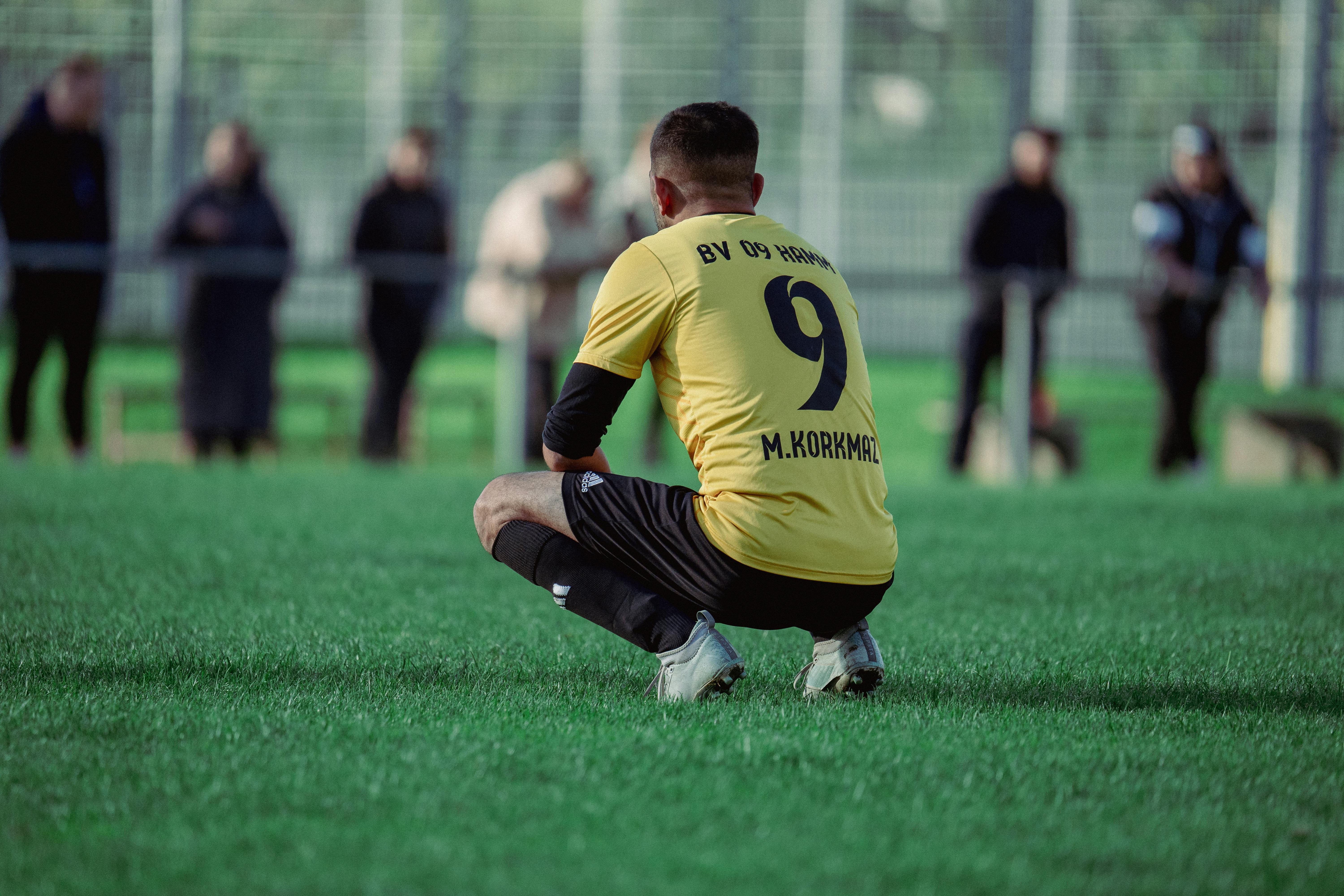 Soccer Player Crouching on Field · Free Stock Photo