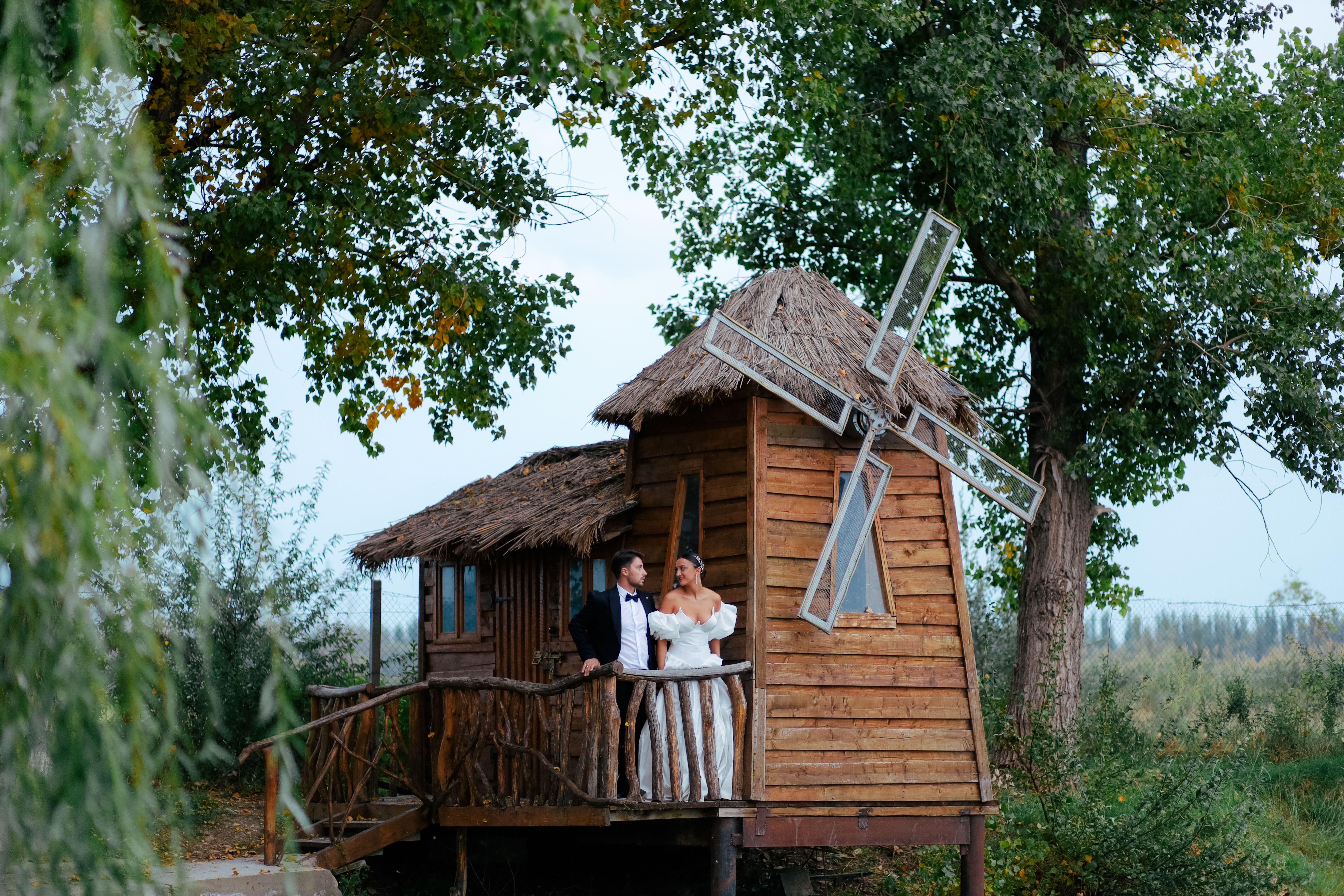 Newlyweds Standing on Porch of Small Windmill · Free Stock Photo