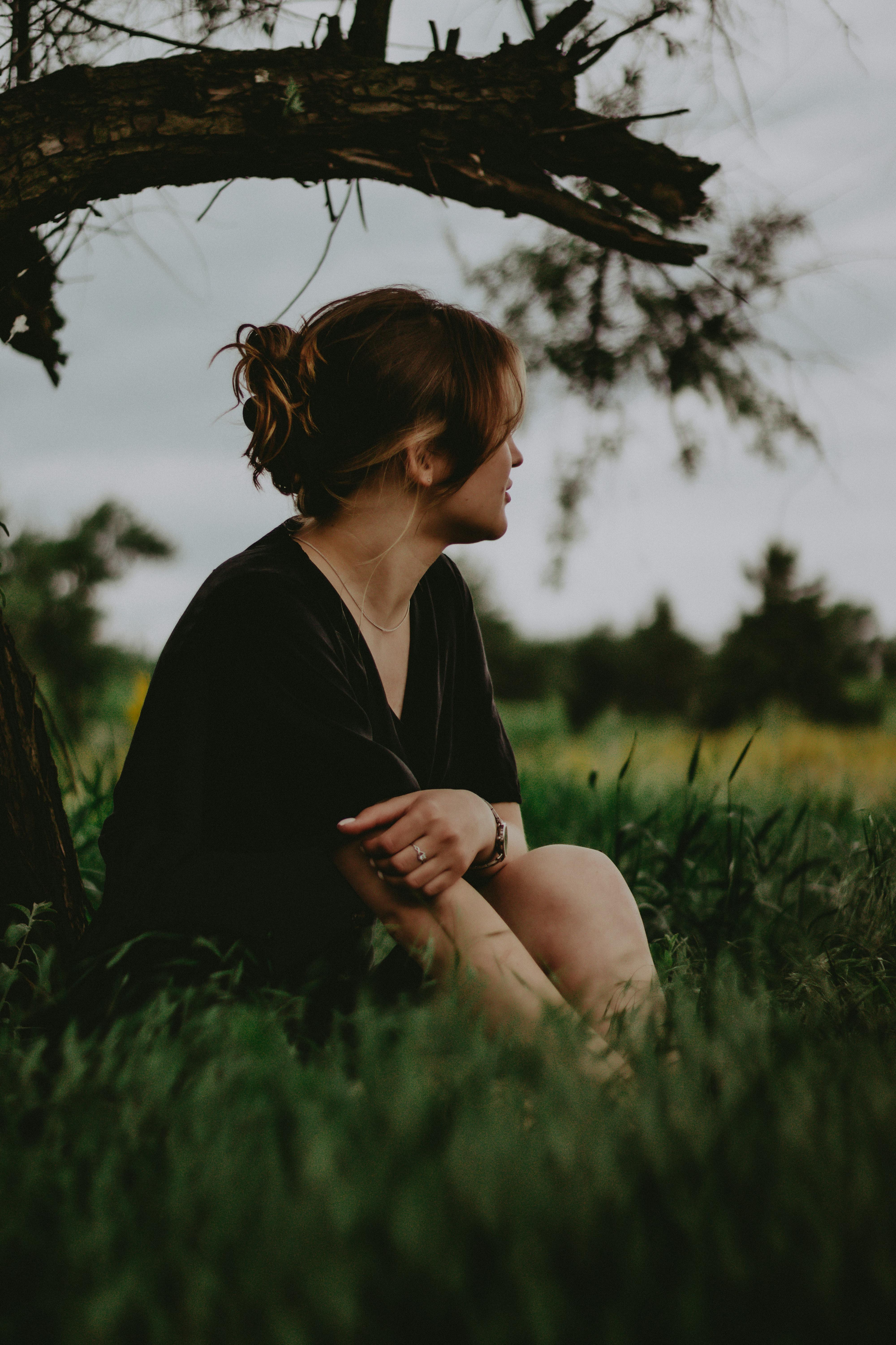 Woman Sitting Under a Tree in Tall Grass · Free Stock Photo