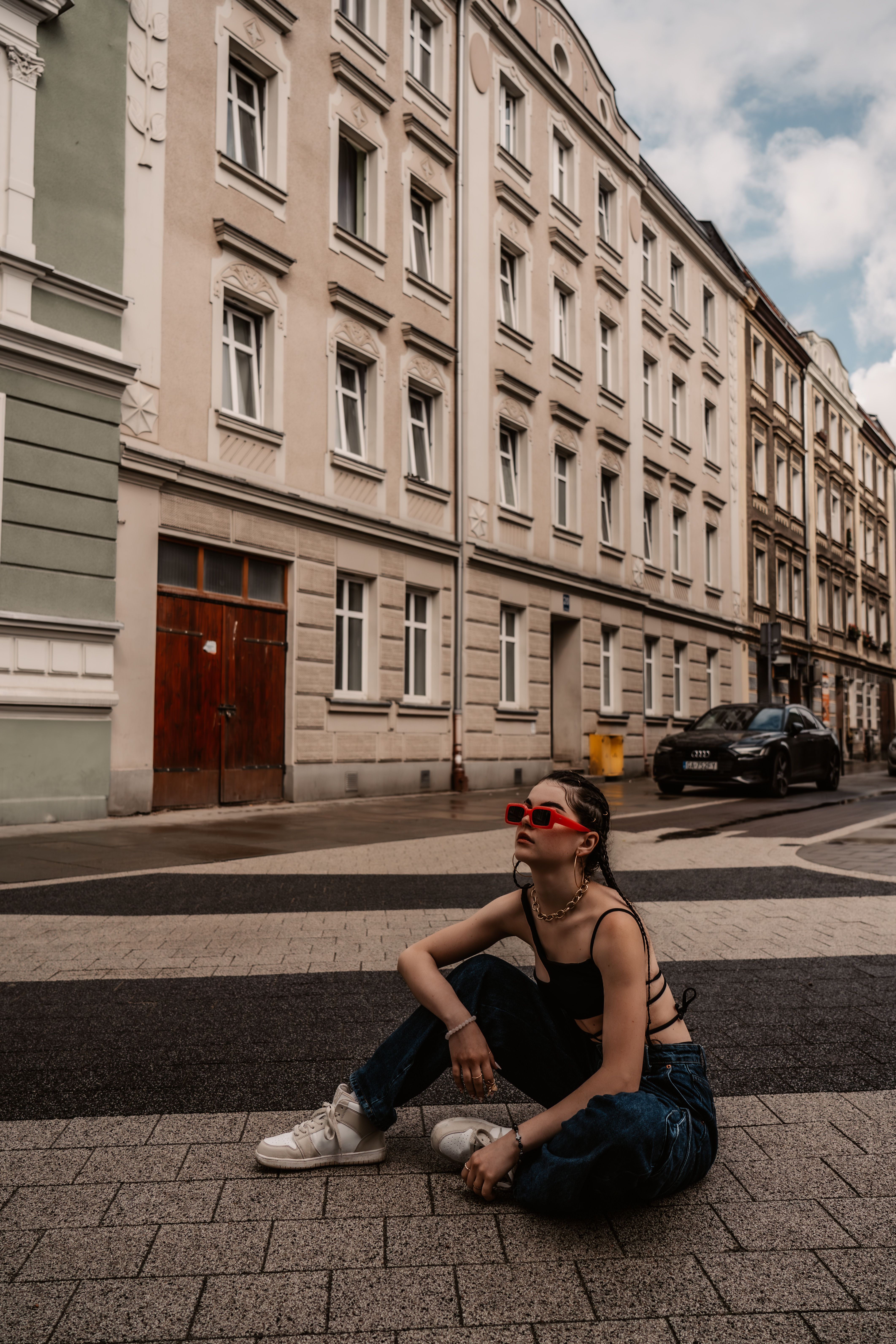 Female Model Sitting in front of a Row of Residential Buildings · Free ...