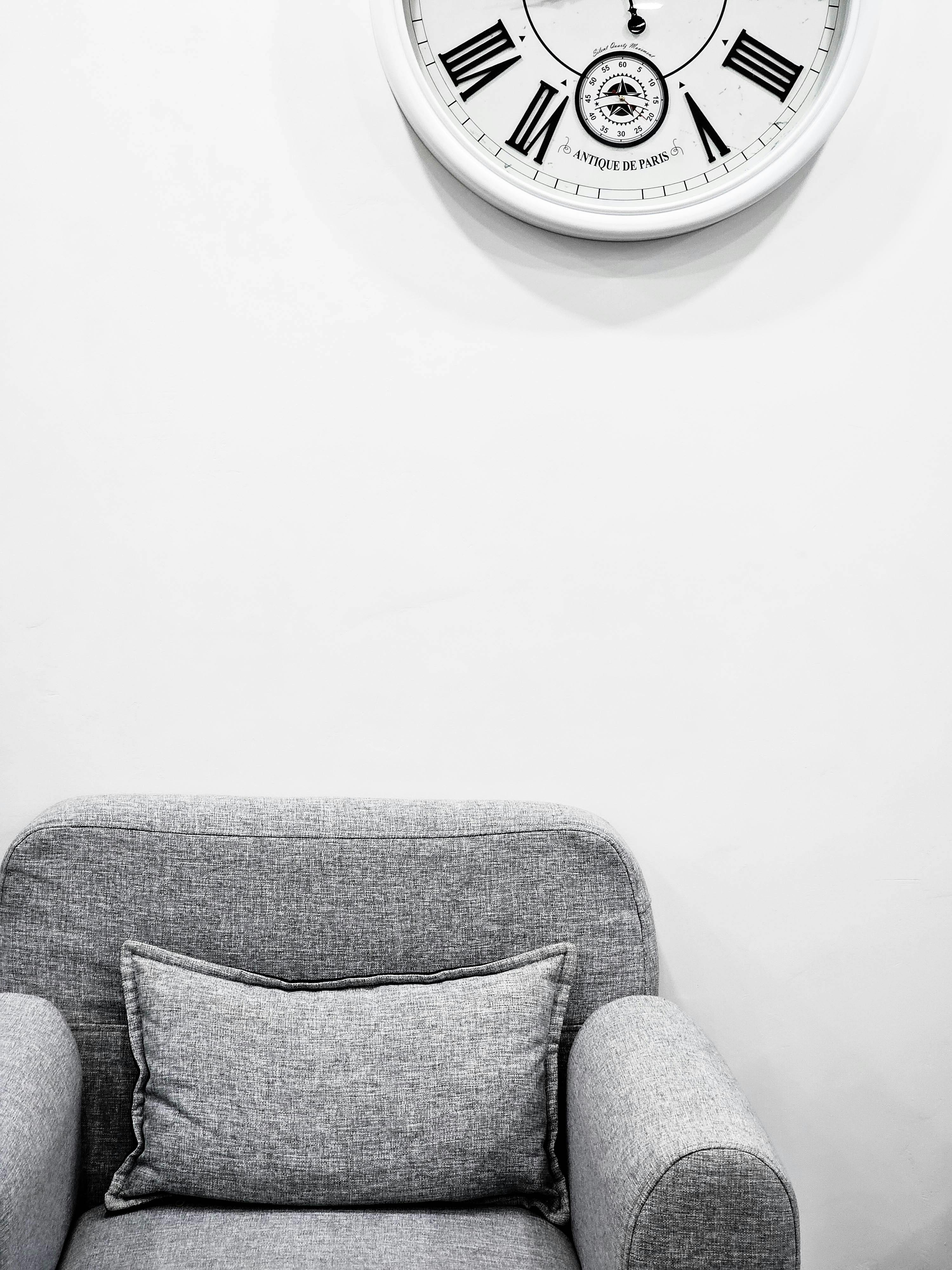 An Armchair and a Clock on a Wall · Free Stock Photo