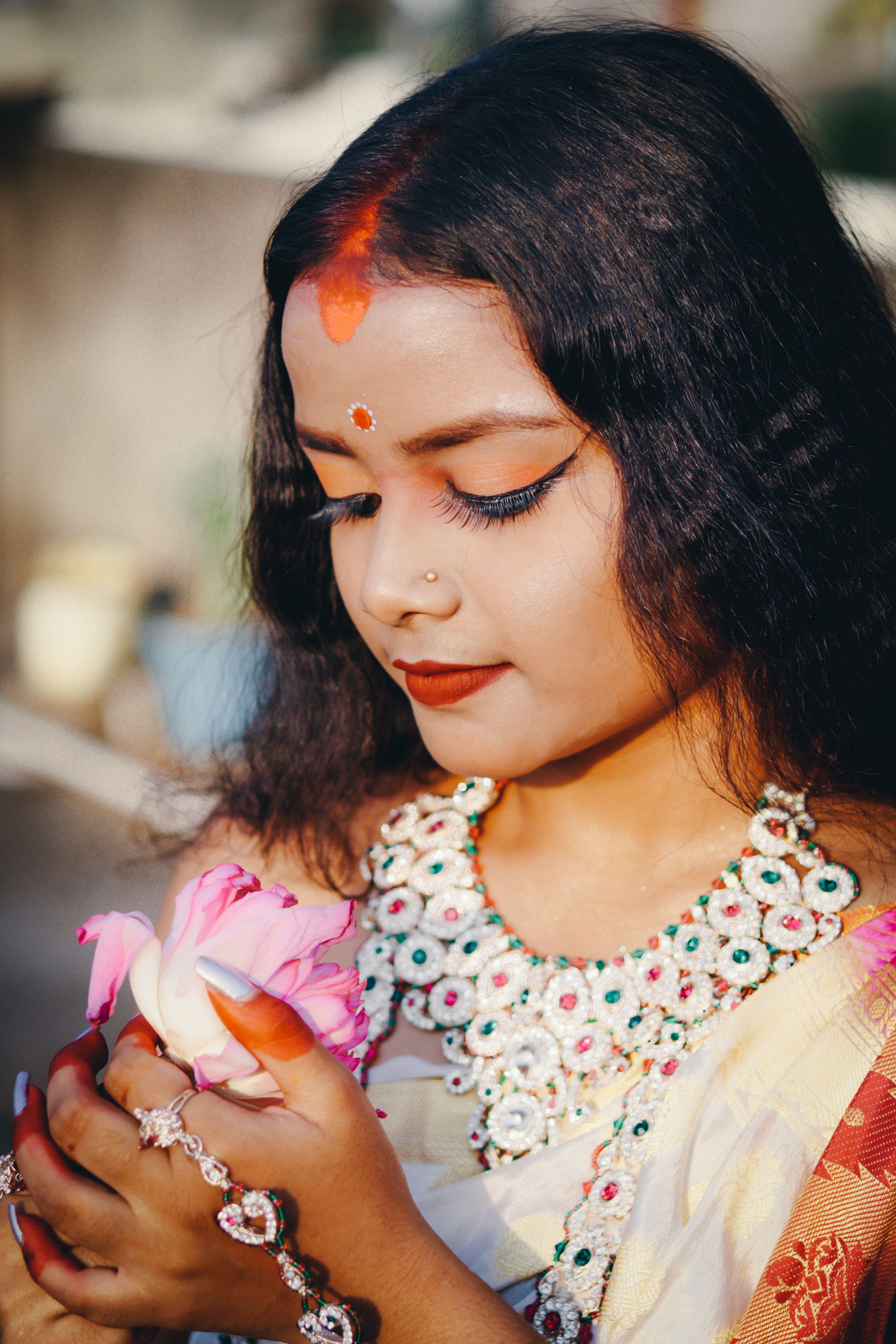 Young Woman with Bindi Holding a Pink Flower · Free Stock Photo