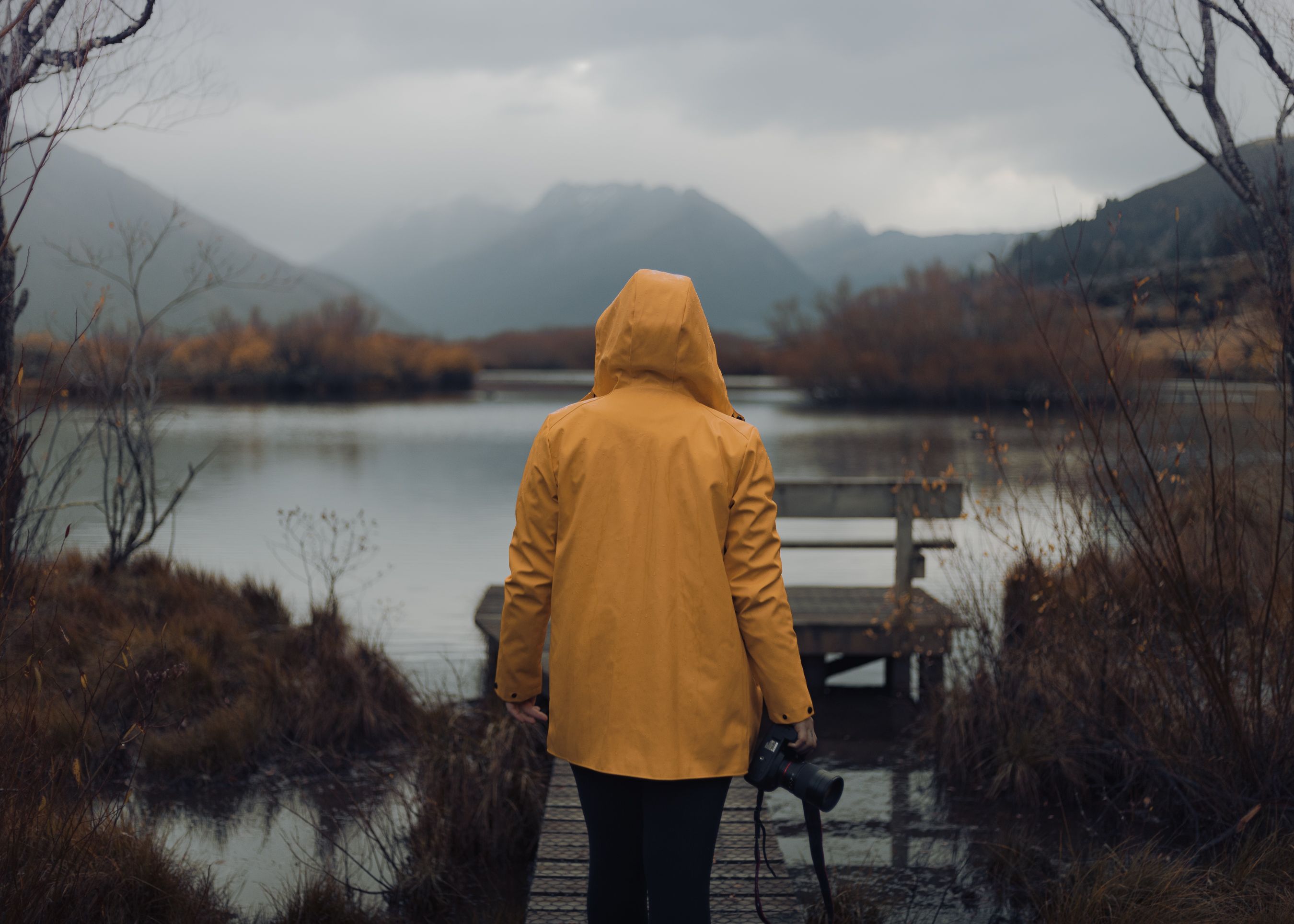 Photographer in a Yellow Raincoat on a Mountain Lake on a Rainy Day ...