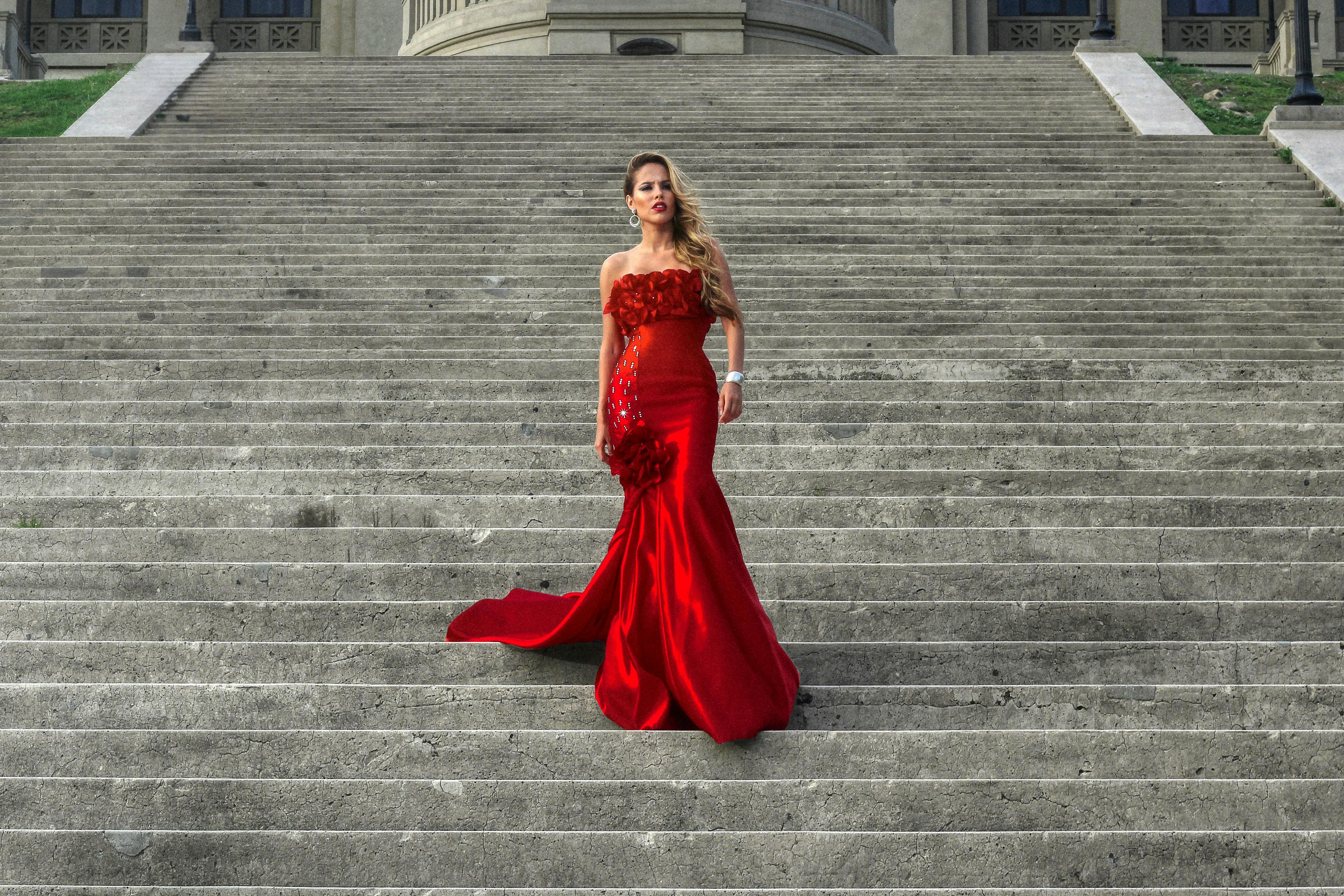 Model in Long Red Dress Posing on Stairs · Free Stock Photo