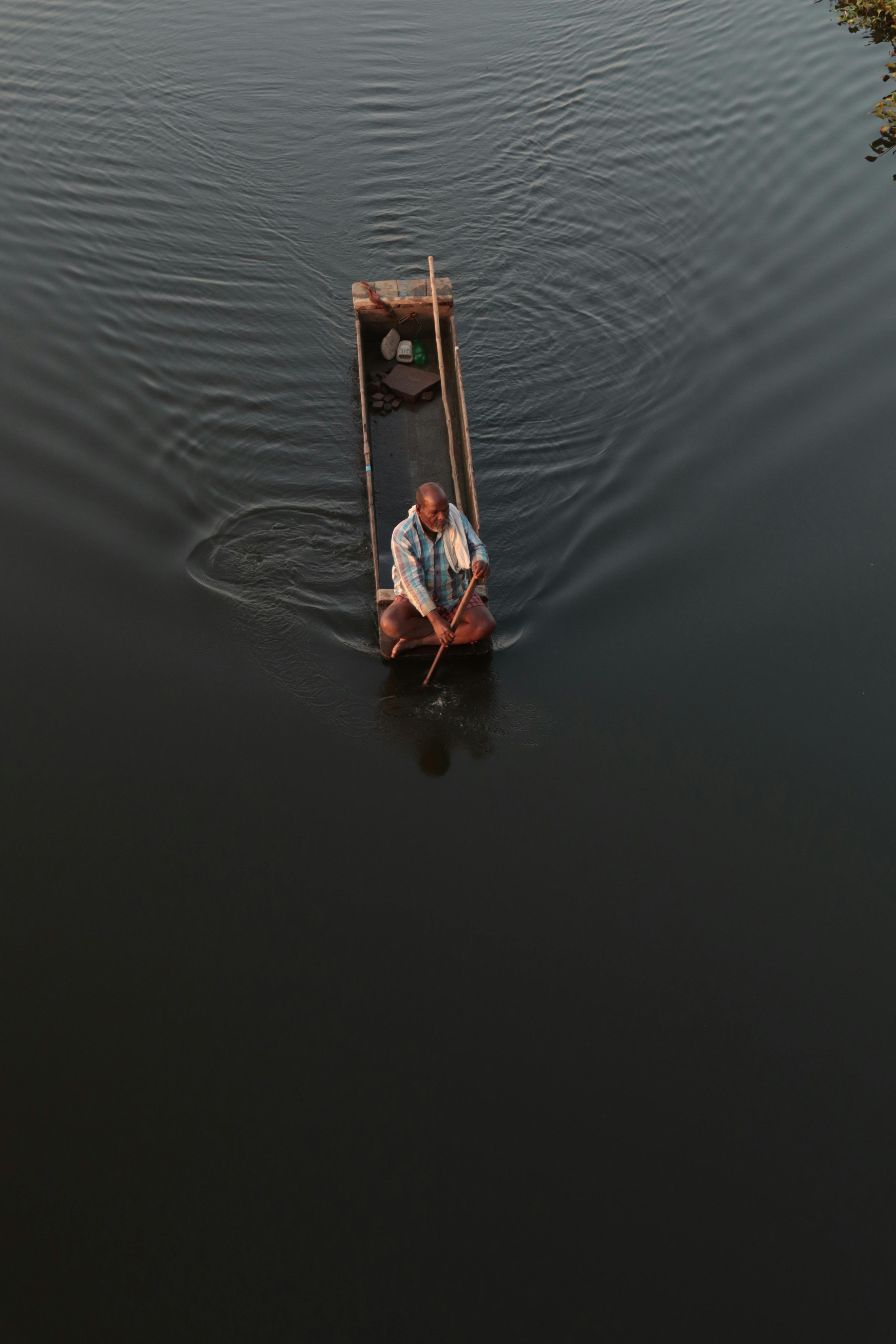 Man Rowing in a Wooden Rectangular Boat · Free Stock Photo