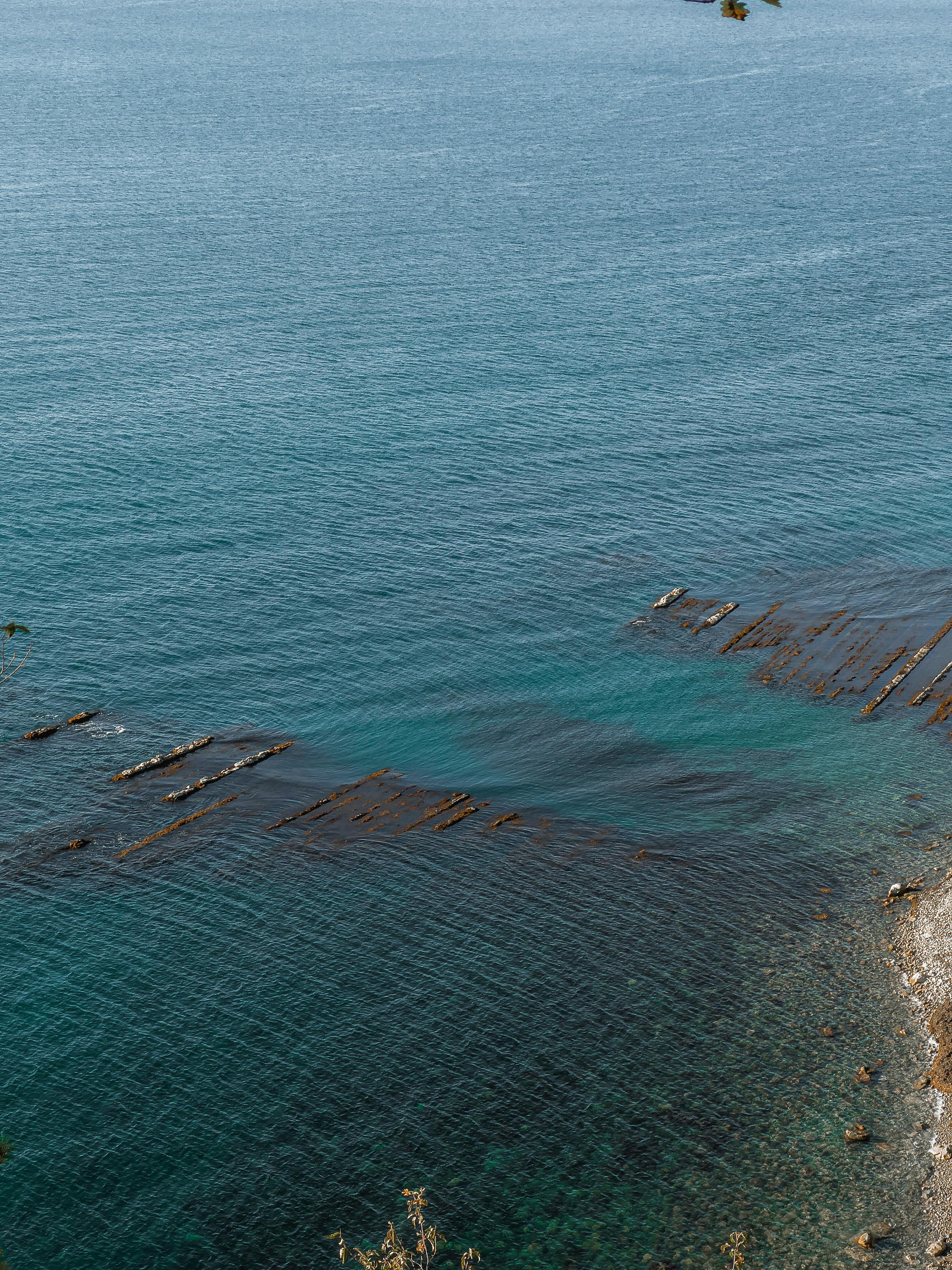 Soaring Rock Formation Photographed from Sea · Free Stock Photo