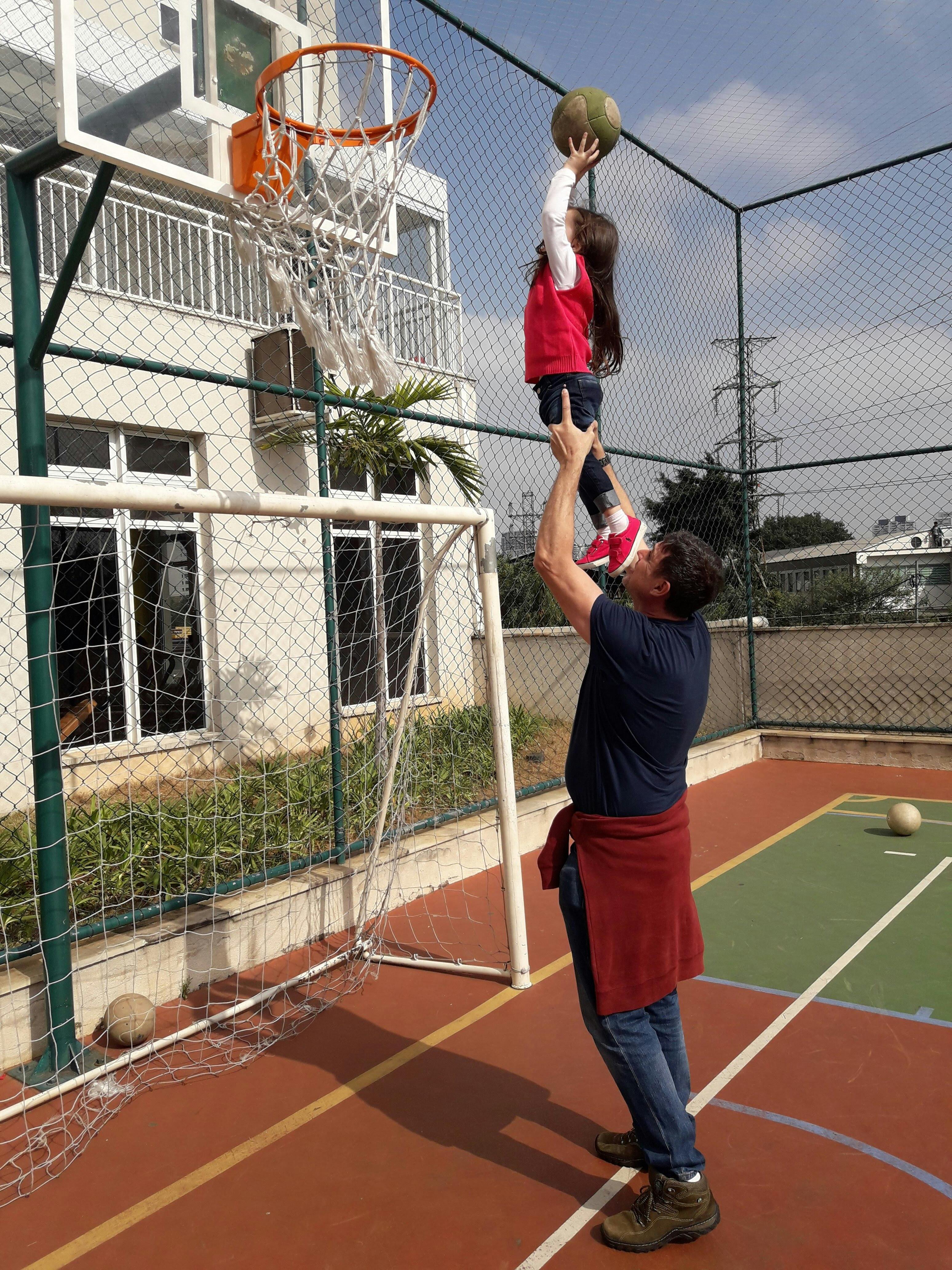 Father Helping His Little Daughter to Put the Ball in the Basketball ...