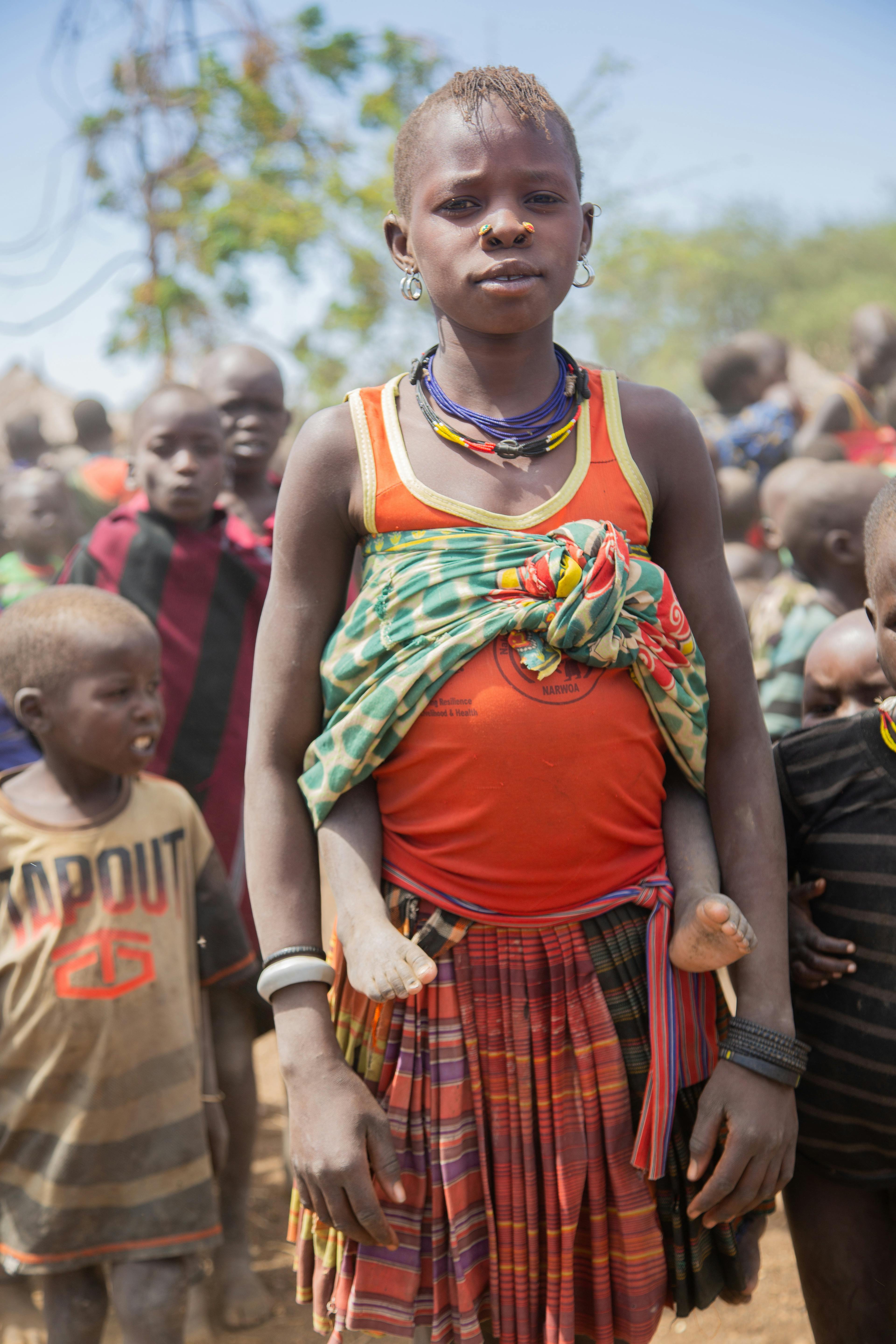Pregnant Woman Carrying Small Child in a Scarf on Her Back in an ...
