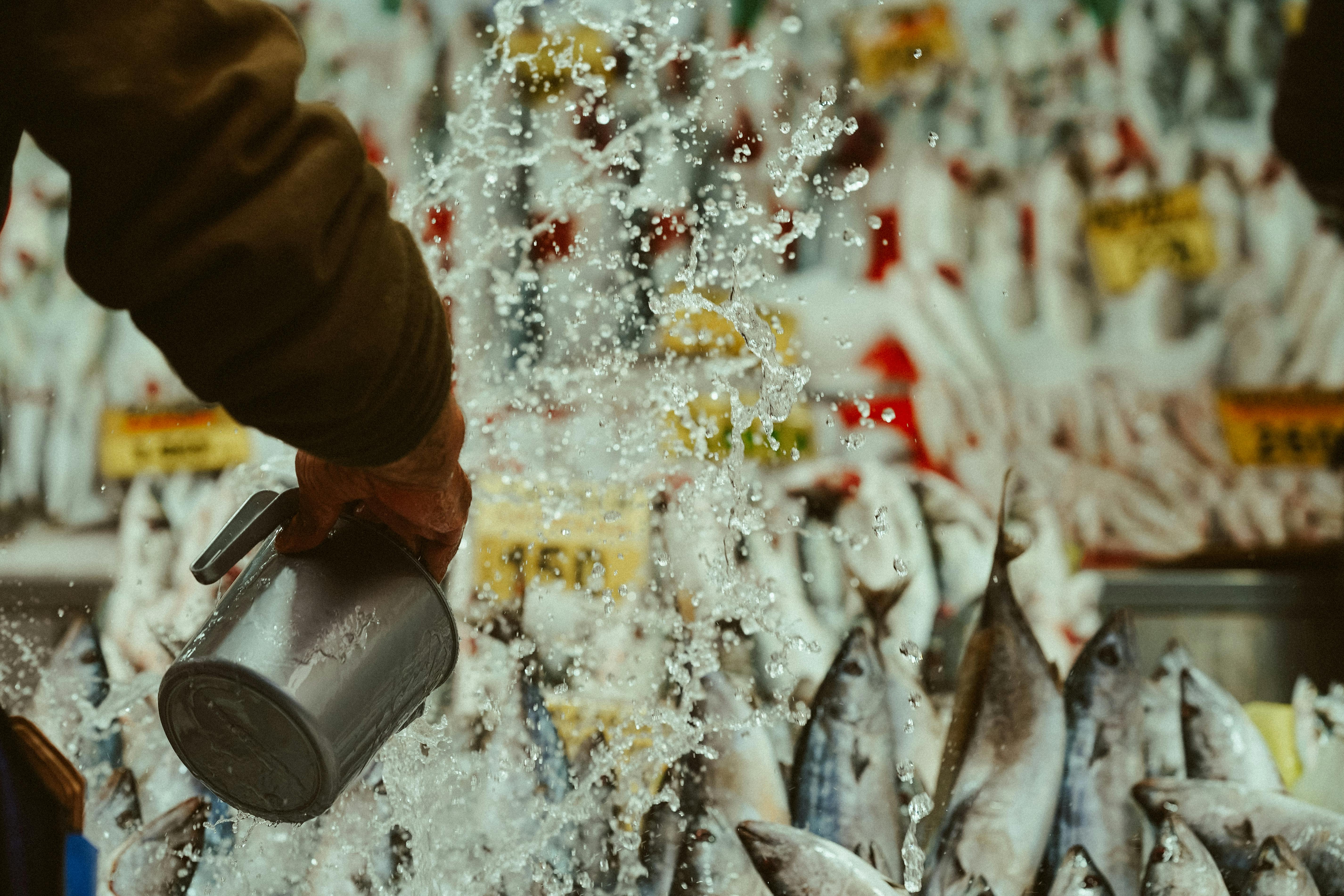 Close-Up Photo of a Person's Hand Touching Body of Water · Free Stock Photo