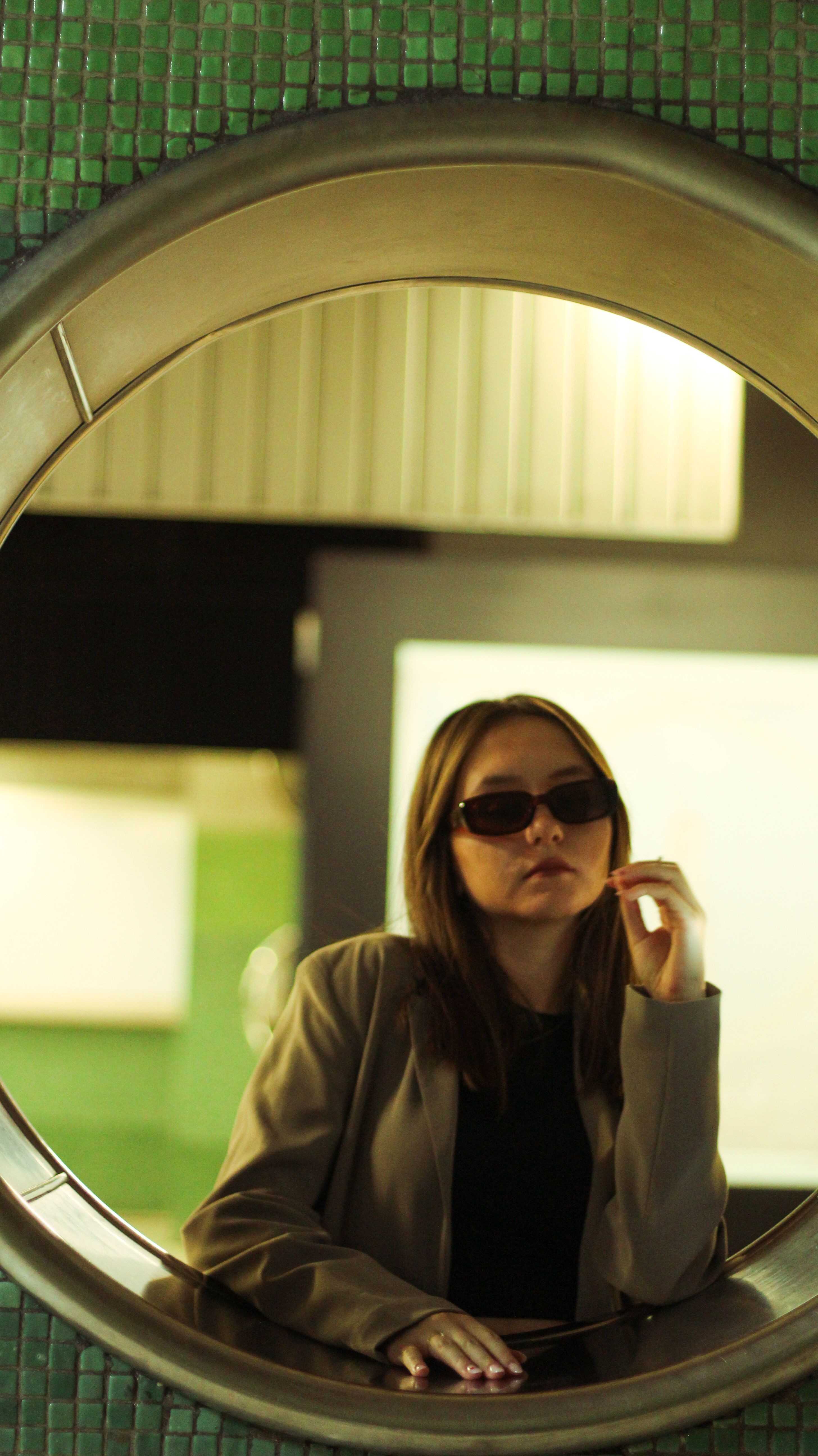 Brunette in Sunglasses Posing in Round Window · Free Stock Photo