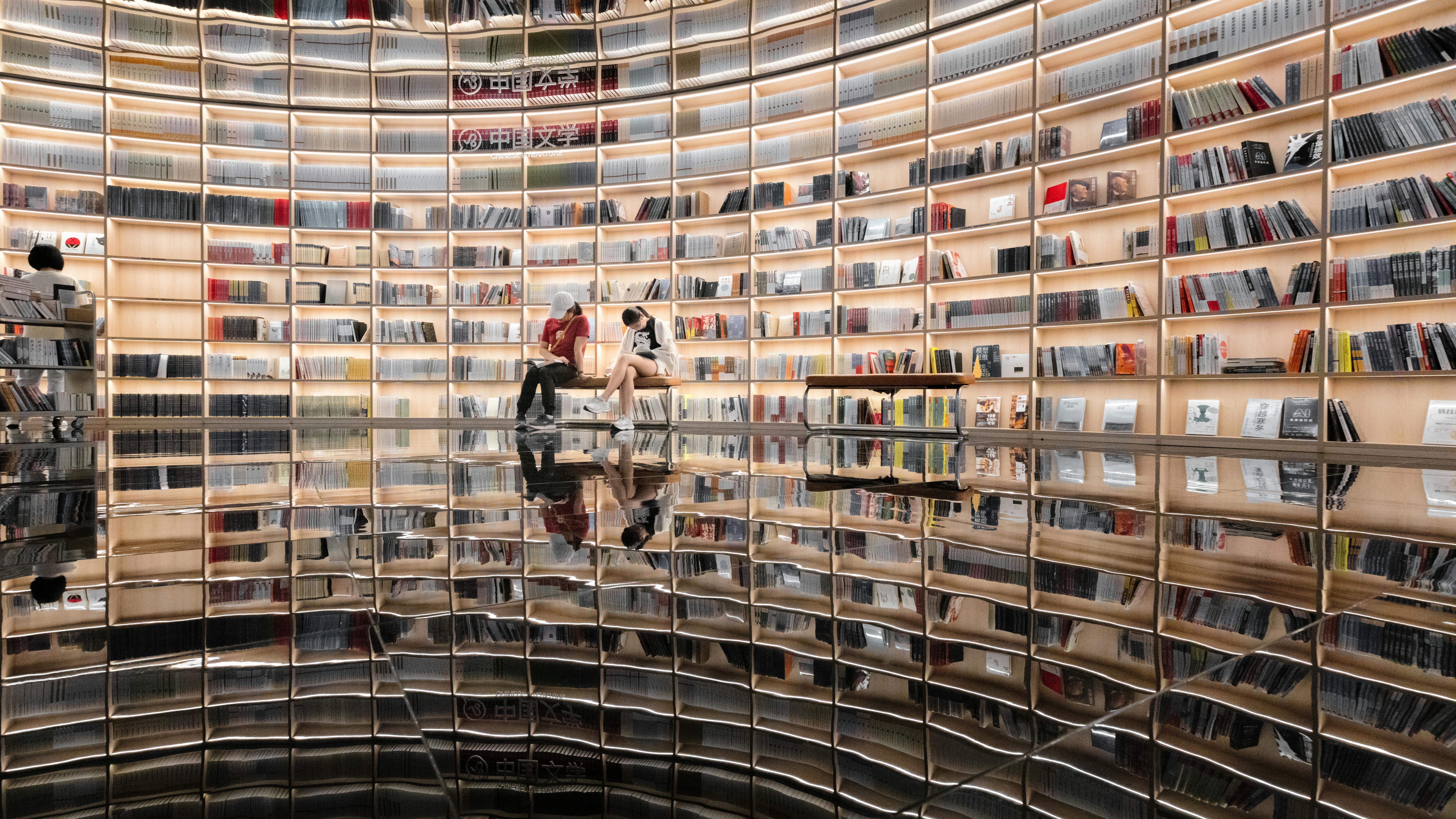 People Sitting in Library with Reflective Floor · Free Stock Photo