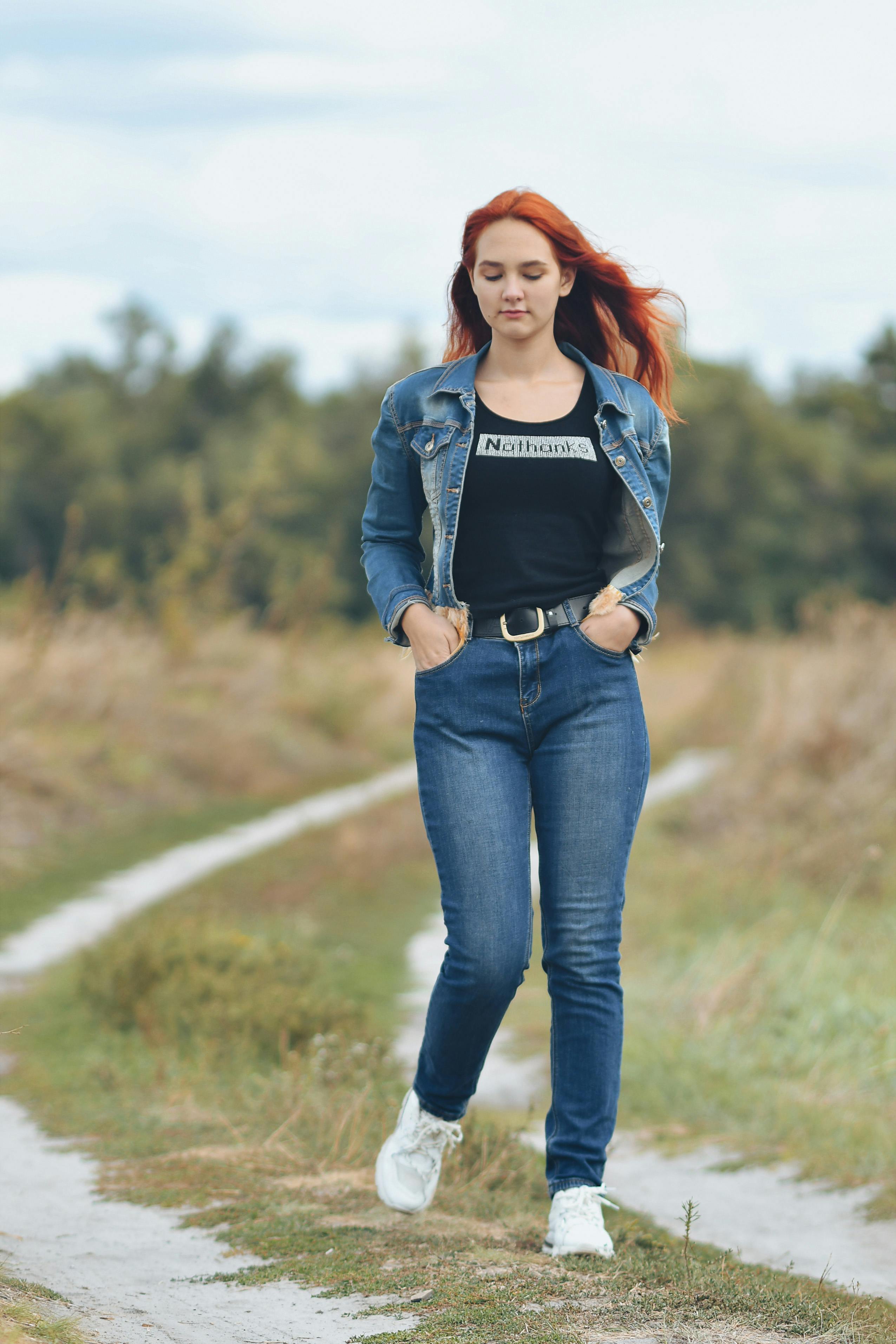 Young Woman in Jeans Walking on a Pathway in the Countryside · Free ...