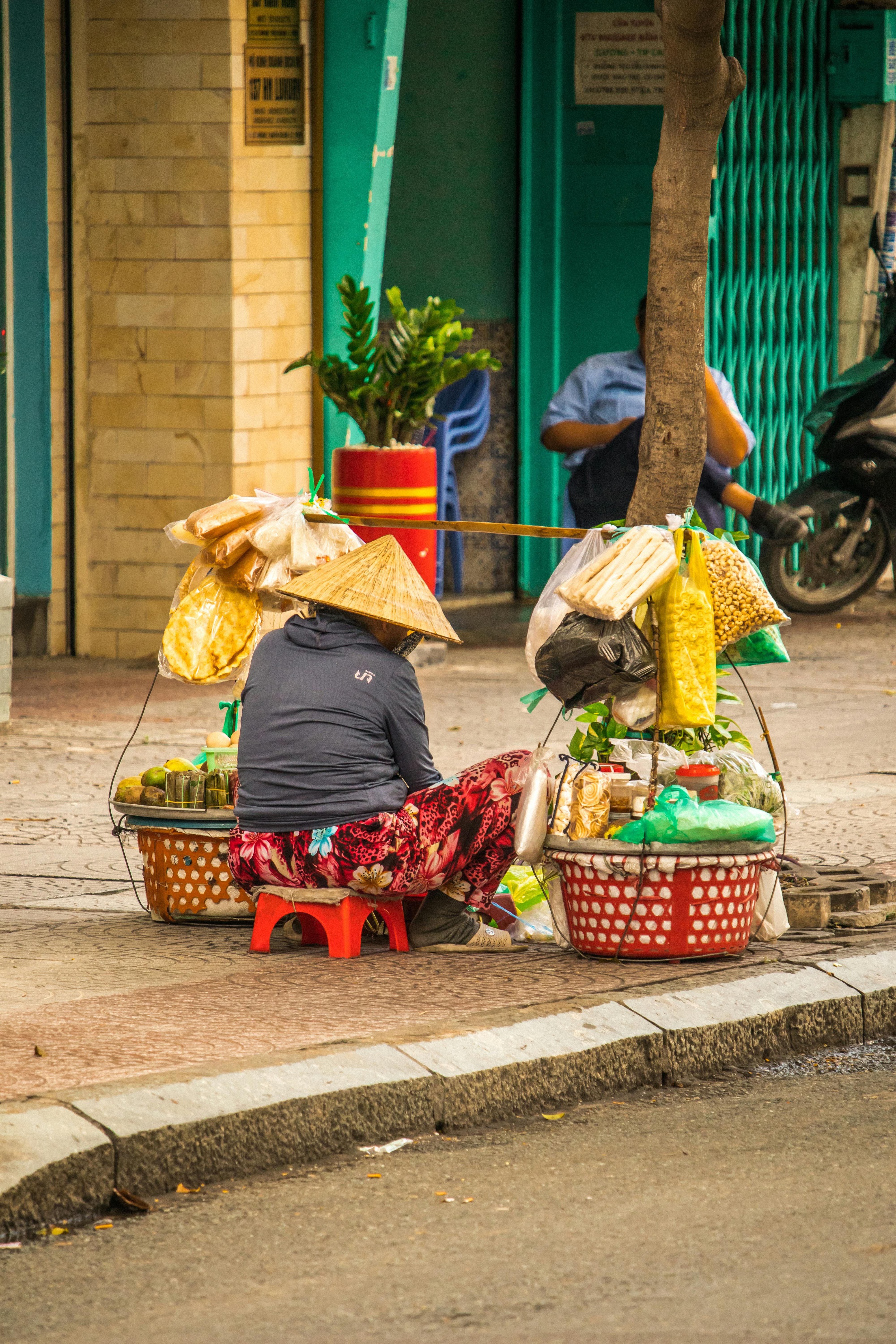 Street Vendor Sitting on Sidewalk · Free Stock Photo